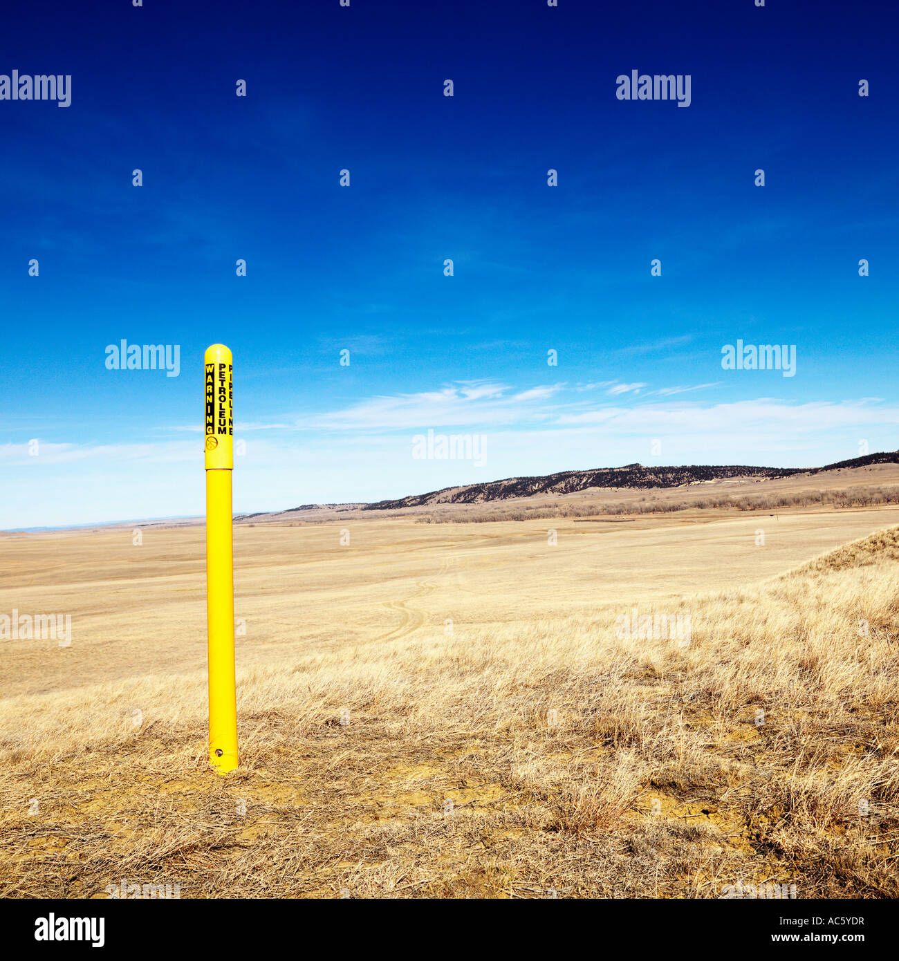 Yellow petroleum warning pole in scenic landscape Stock Photo - Alamy