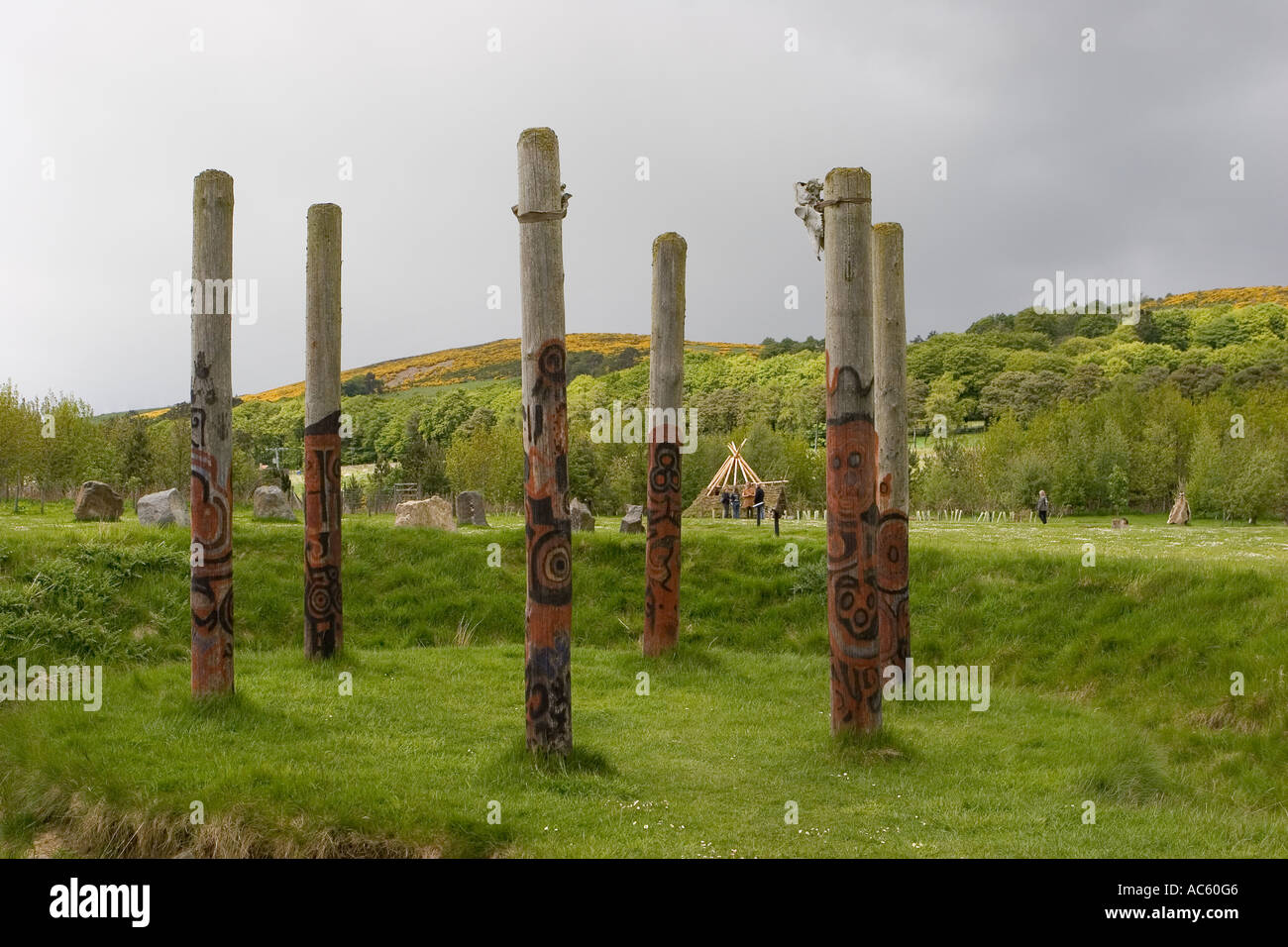 6 painted carved wooden Totem Poles in a circle at the Archaeolink ...