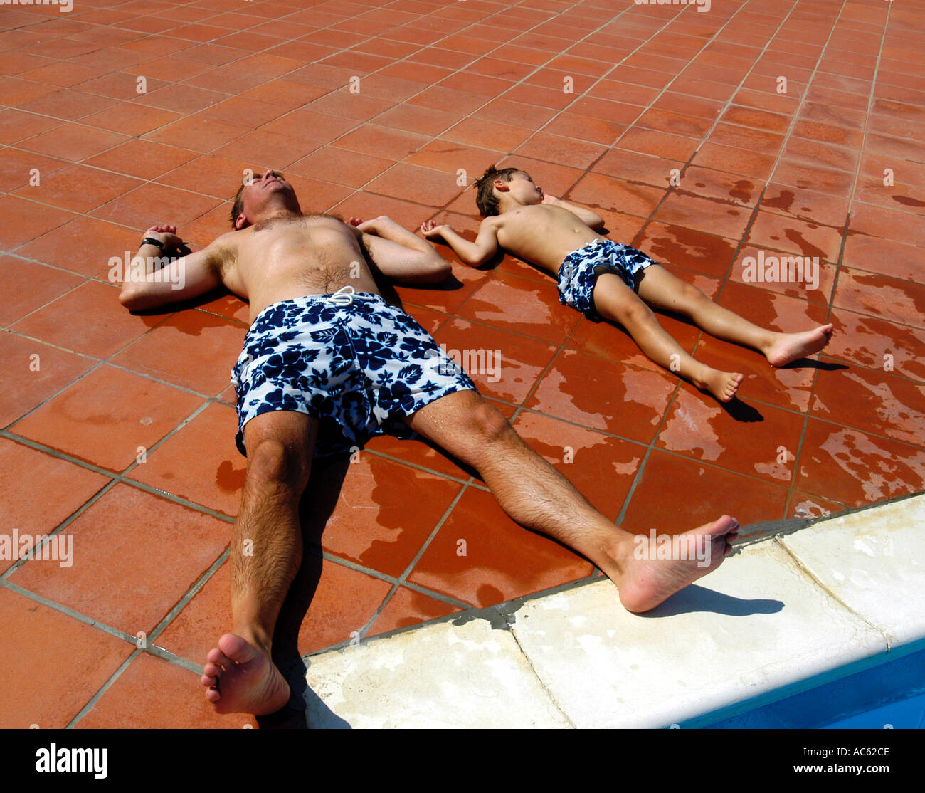 Man Boy lying by side of swimming pool Stock Photo - Alamy