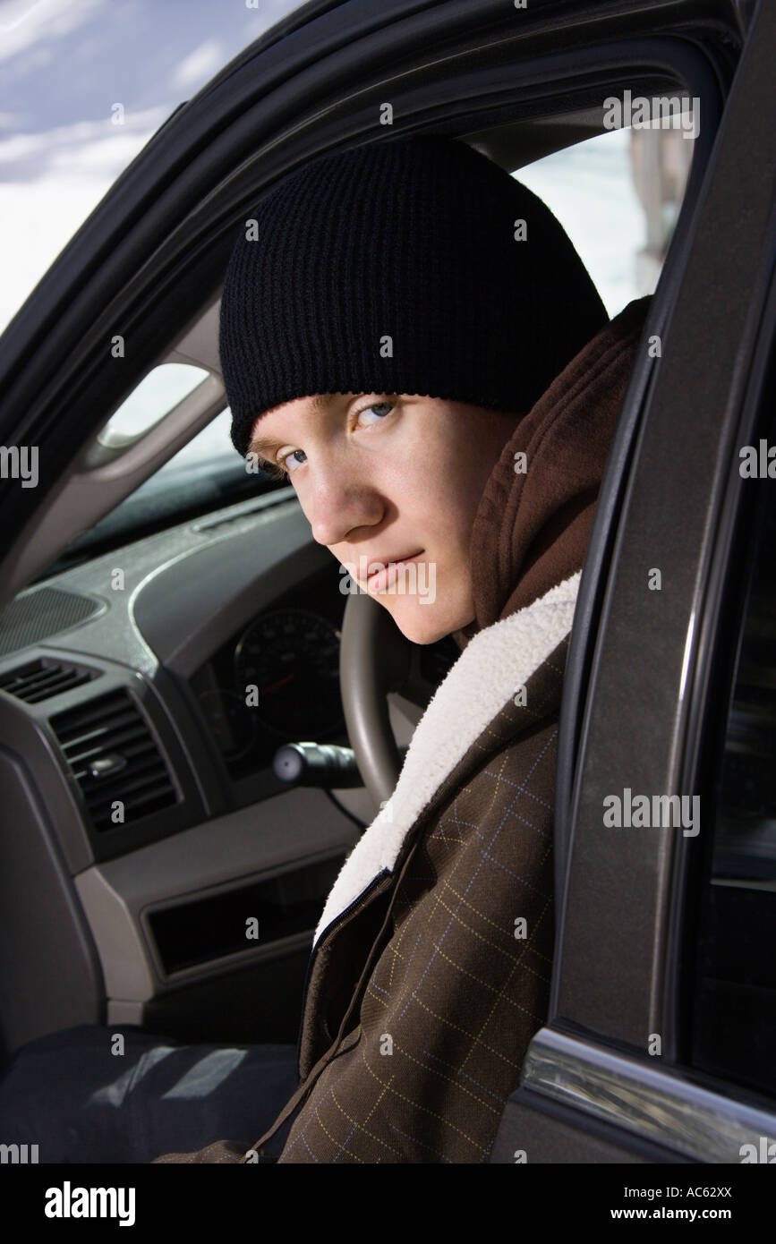 Caucasian male teenager sitting in car looking back at viewer Stock ...