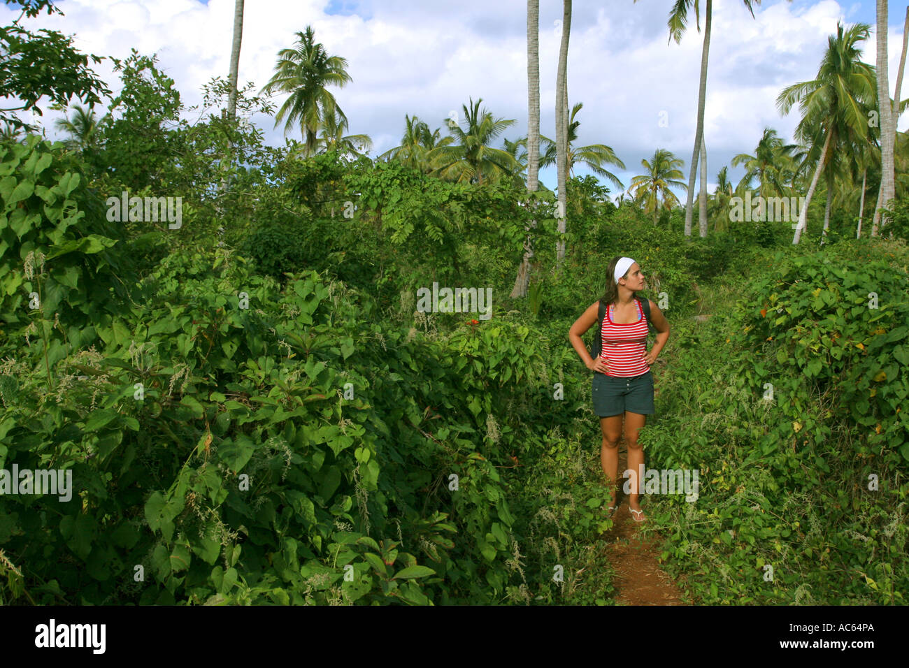 YOUNG WOMAN EXPLORER EXPLORING TREKKING IN THE JUNGLE FOREST A young ...