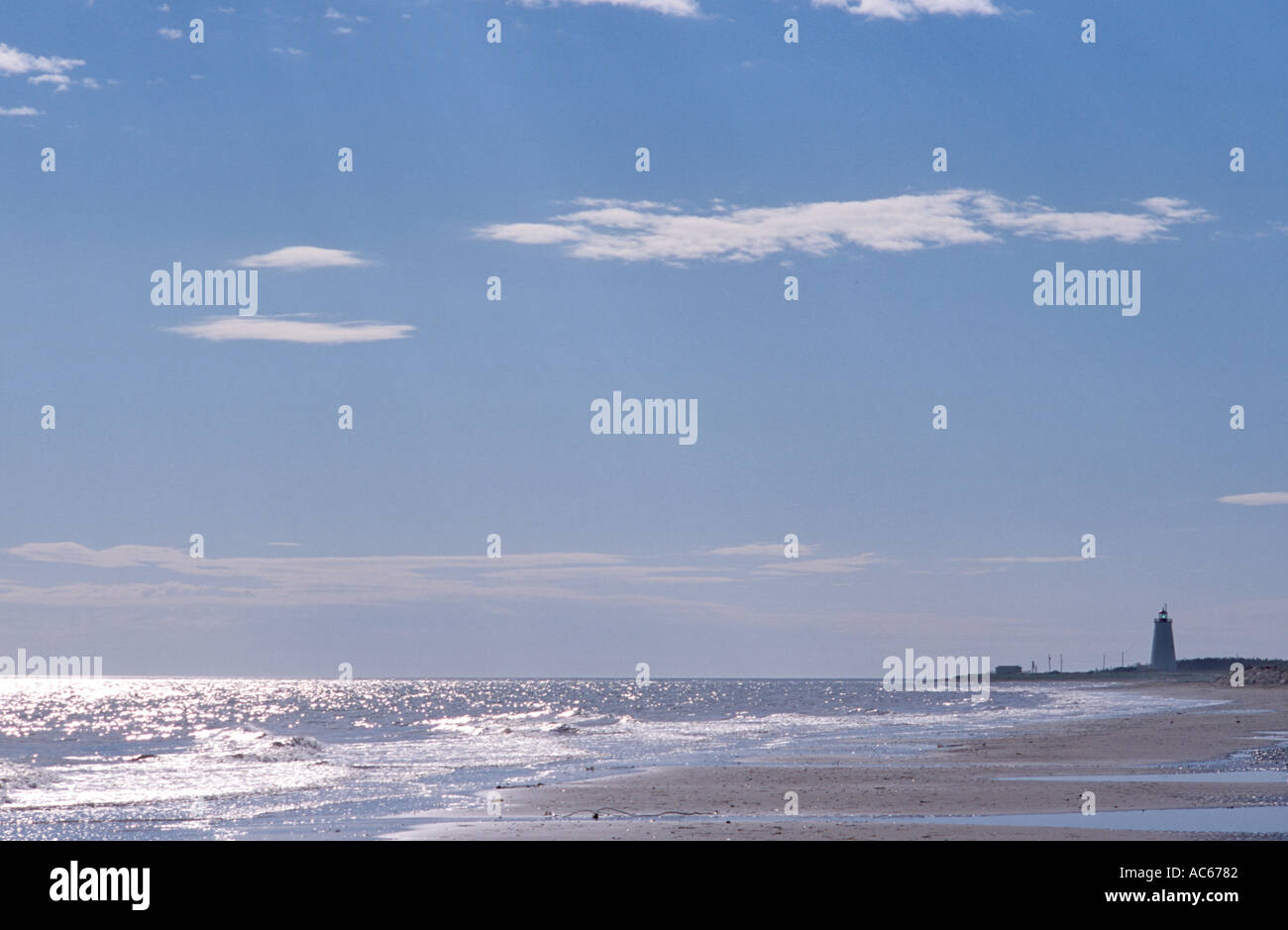 long sandy beach with silver waves and lighthouse Stock Photo - Alamy