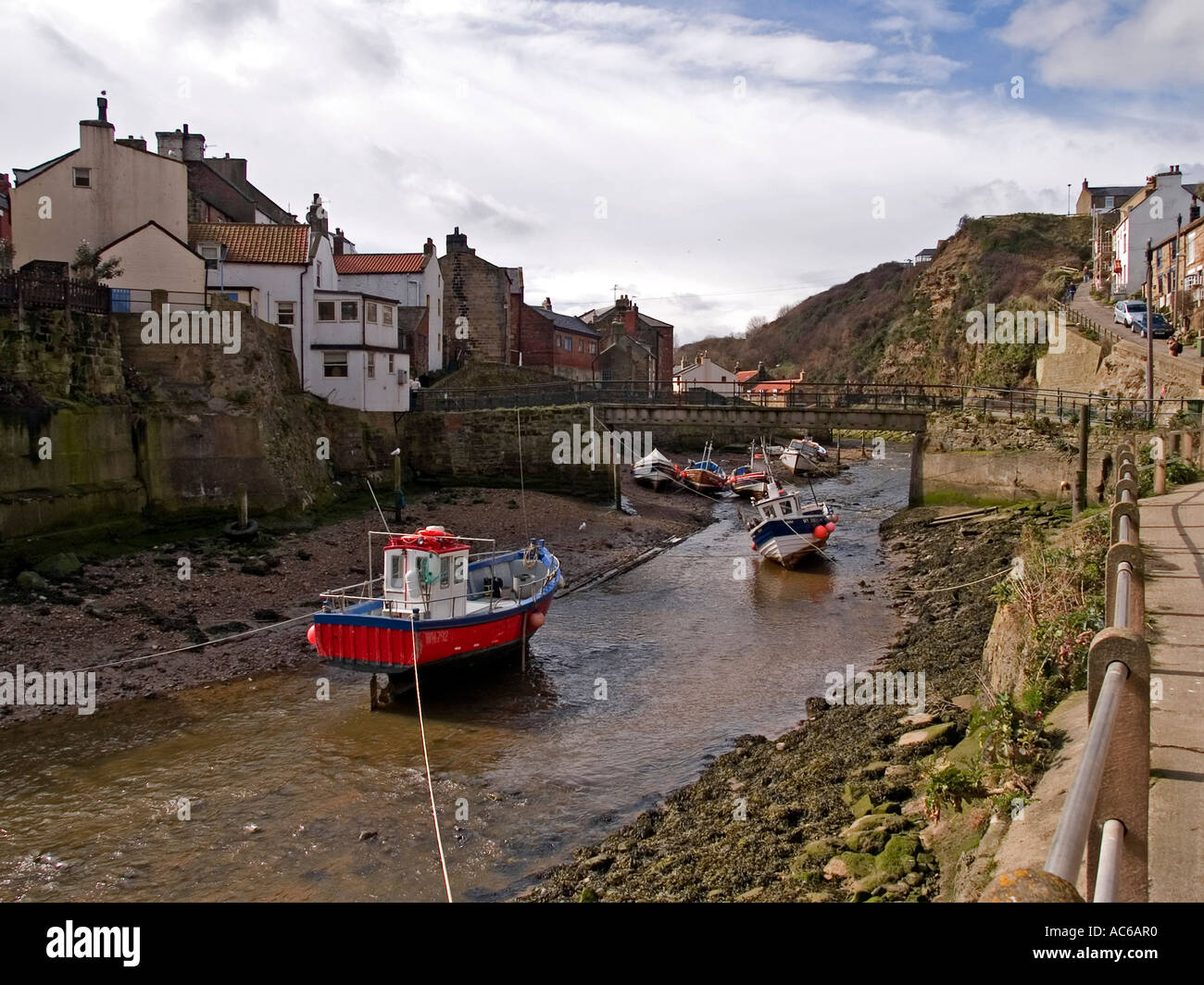 Fishing boats are tied up in the shelter of Roxby Beck at Staithes ...
