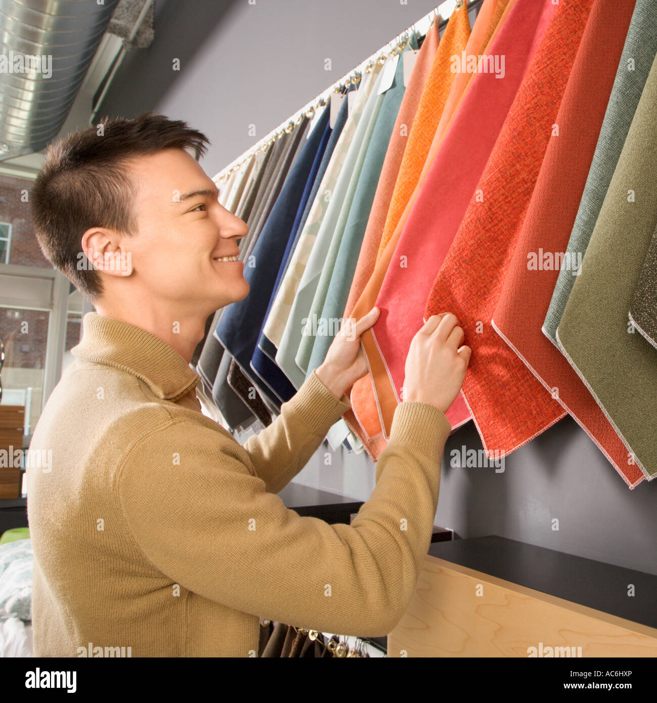 Asian male looking at fabric swatches in retail store Stock Photo - Alamy