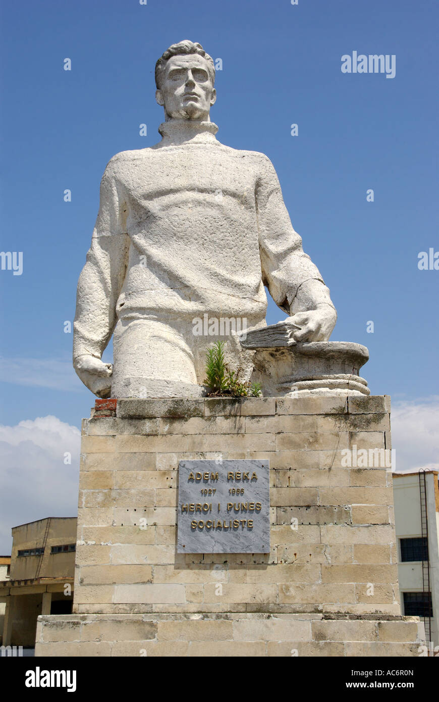 Durres Albania dockside statue with inscription Adem Reka Heroi I Punes ...
