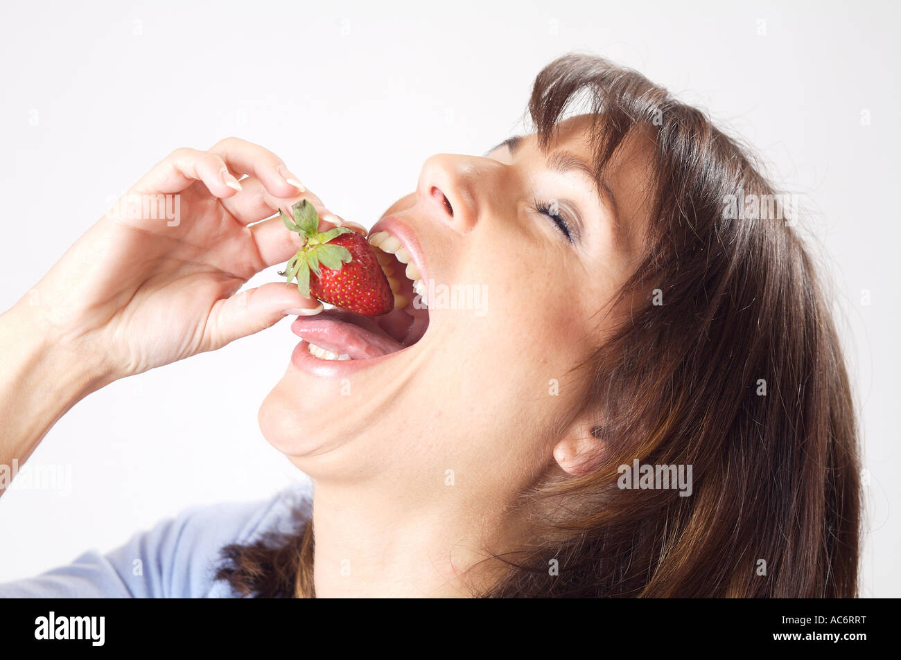 Eine junge Frau isst eine Erdbeere a woman eating a strawberry portrait ...