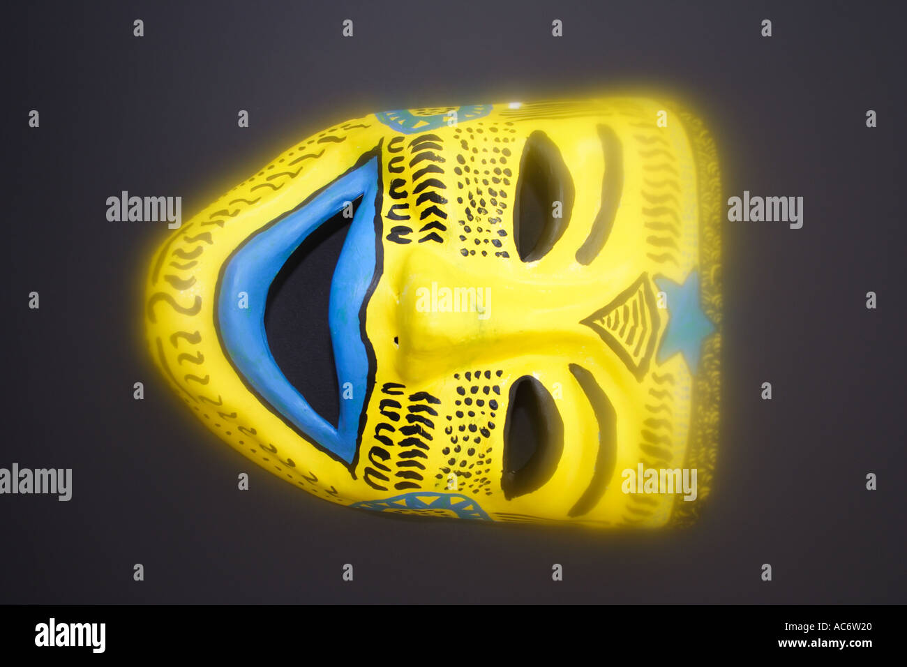 YELLOW AND BLUE PAINTED MASK BLACK BACKGROUND BAPD2373 Stock Photo - Alamy