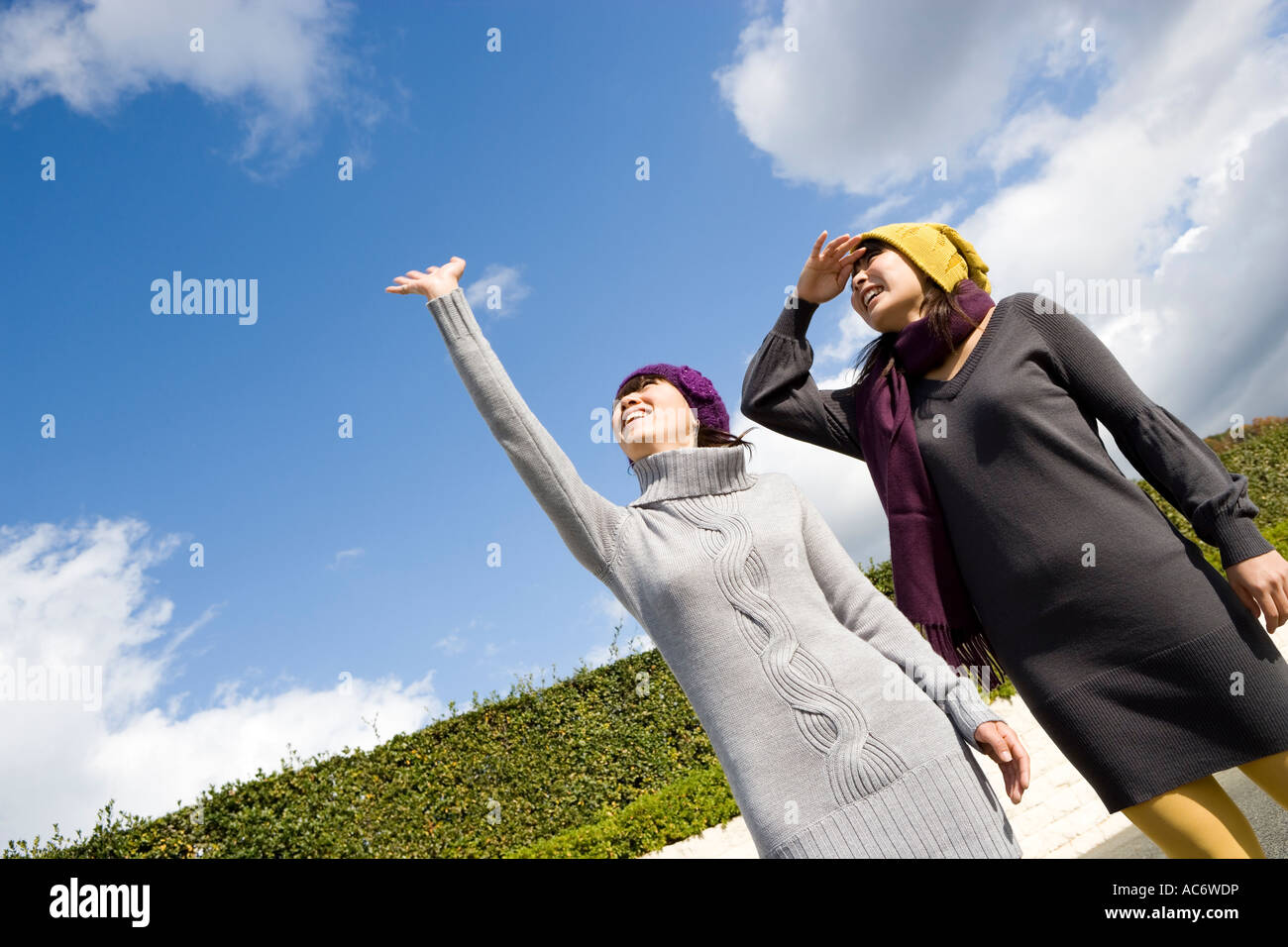 Two young women looking up Stock Photo - Alamy