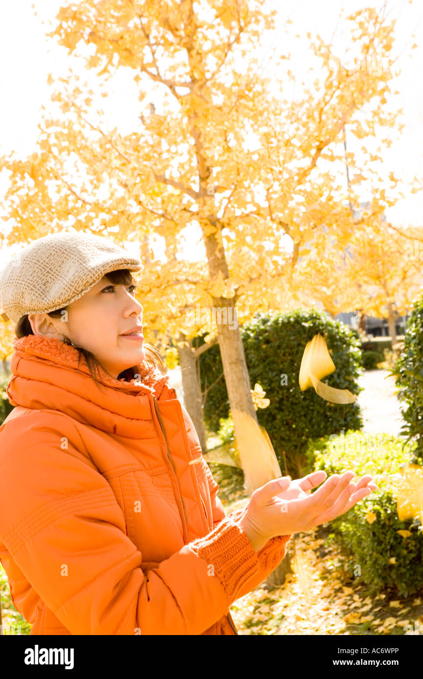 Young woman catching falling leaves Stock Photo - Alamy