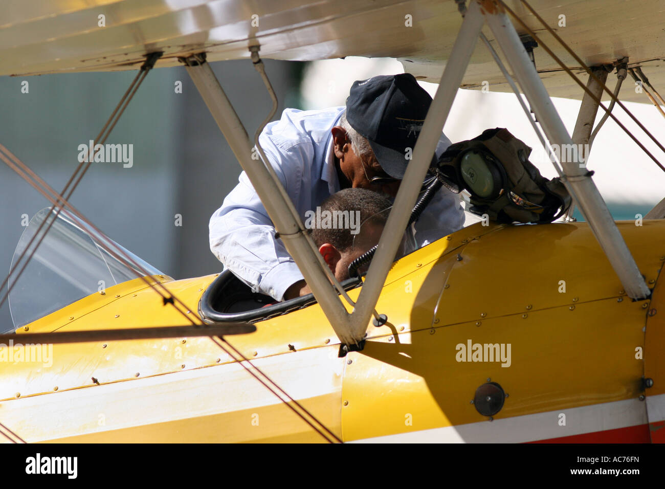 A new pilot getting buckled into the front cockpit of a biplane Stock ...