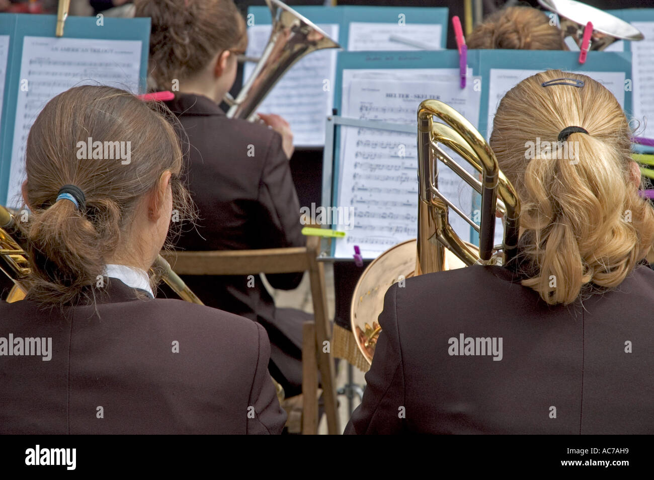 a view from behind of two teenage girls playing instruments in a brass ...