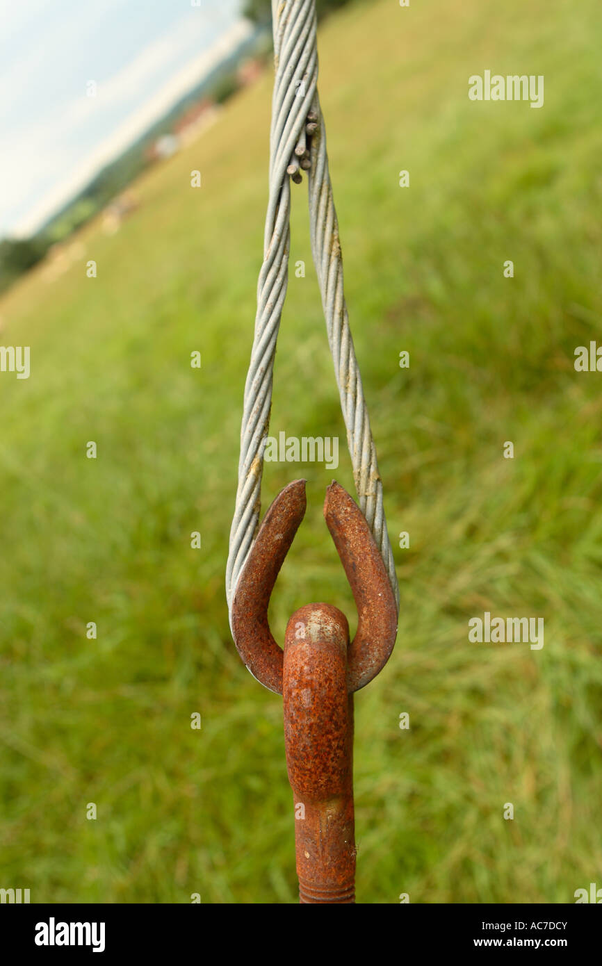 Metal stake holding twisted steel cable supporting an upright pole ...
