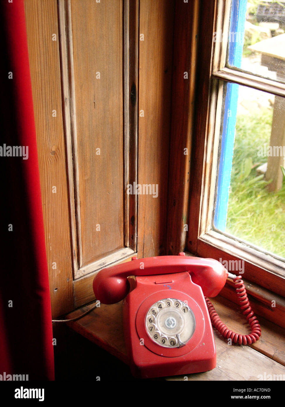 An old red dial telephone on a window ledge of a house in Aberarth ...