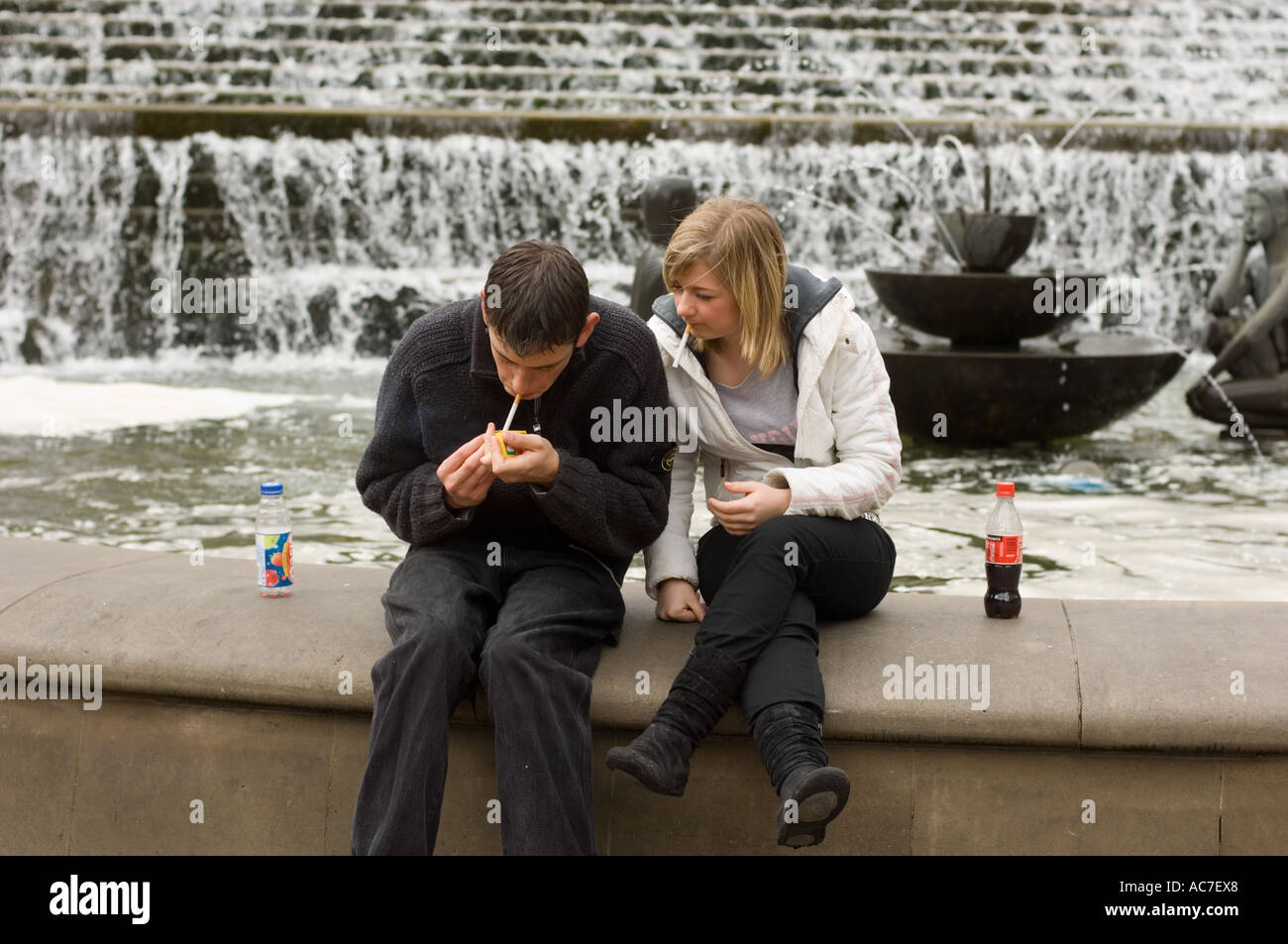 man lighting a cigarette for his girlfriend Birmingham city centre UK ...