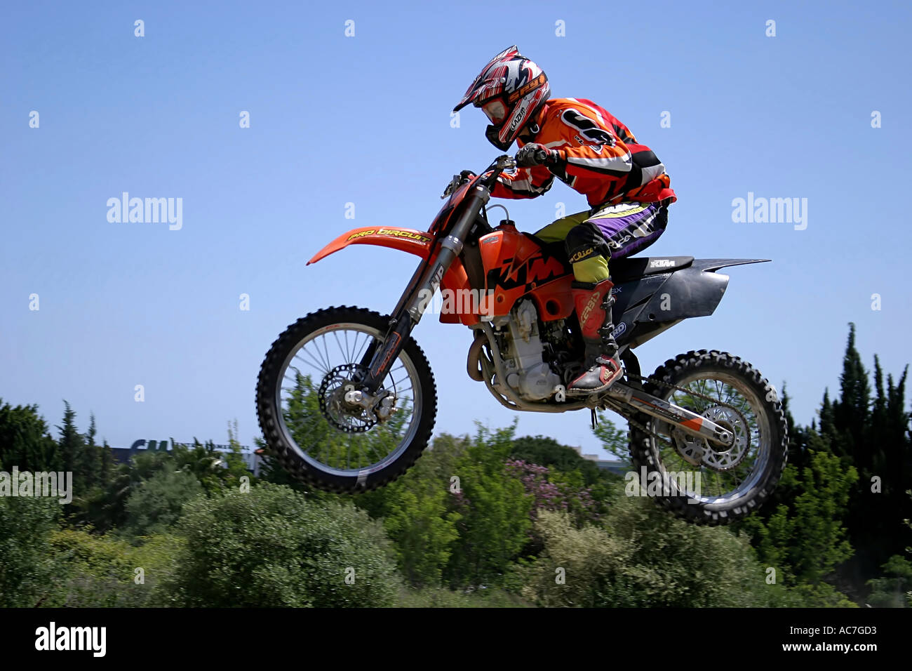 Red and orange Moto x or motor cross bike giving big air on dirt track ...