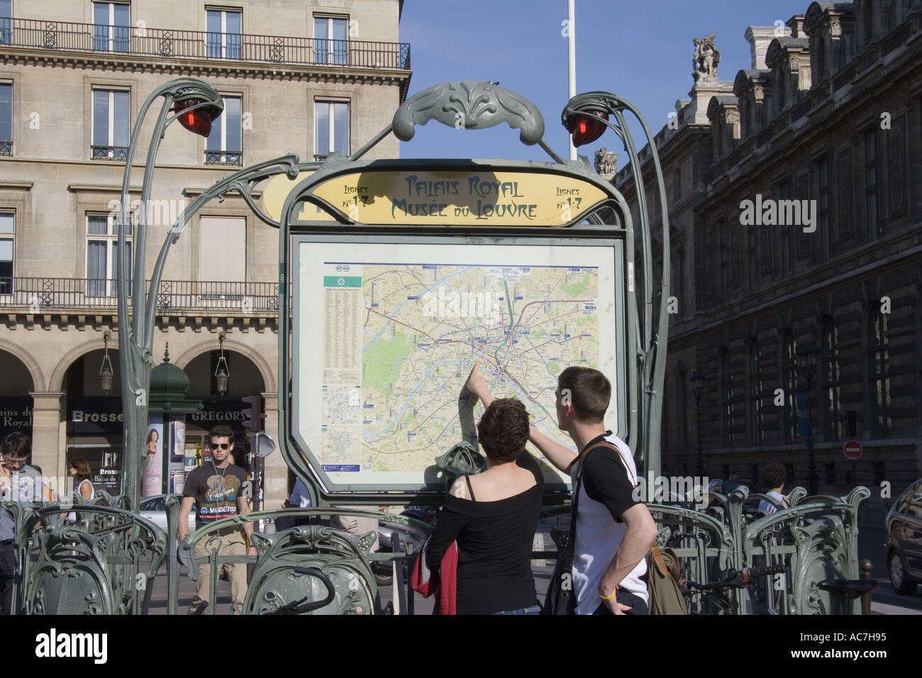Couple points to location on Metro map at the Palais Royal Musee du ...