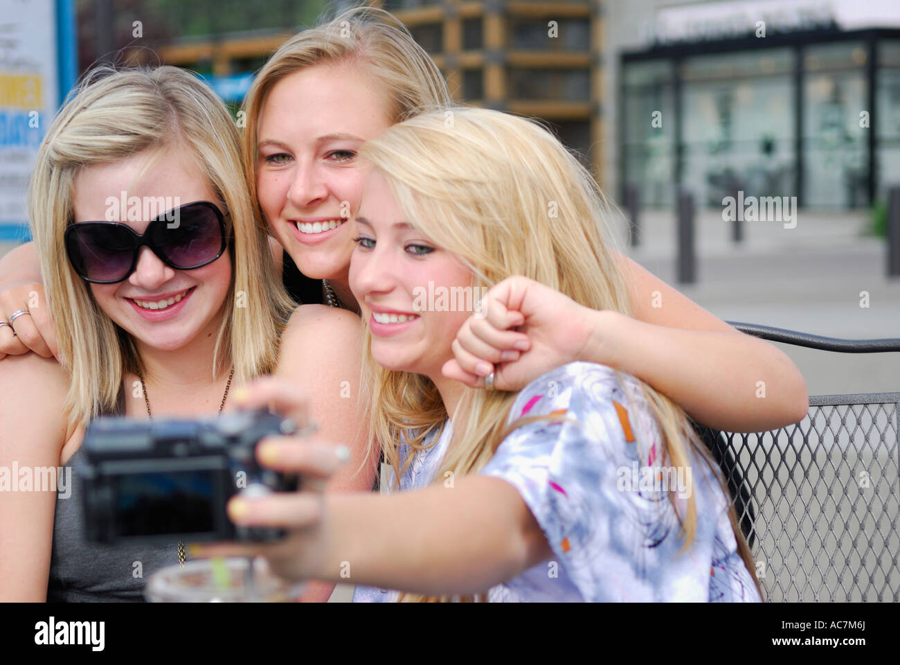 Three young women taking a selfie self portrait with a digital camera ...