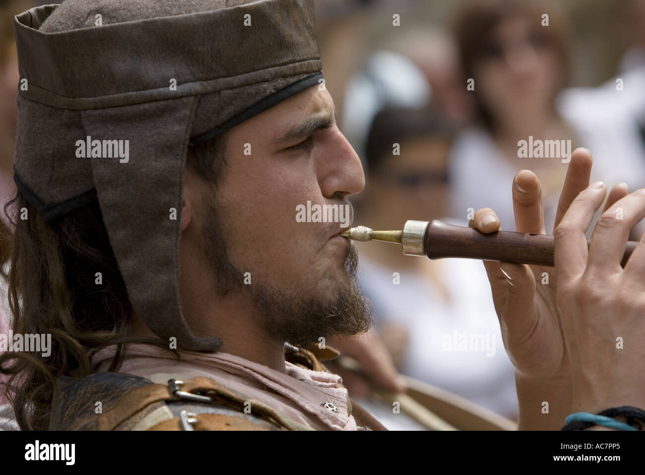 Male musician in period dress playing wind instrument at a medieval ...