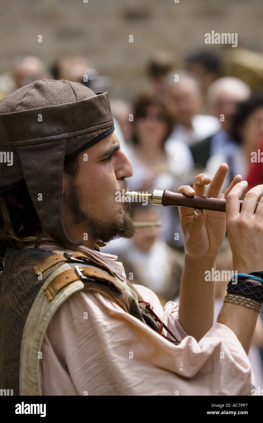 Male musician in period dress playing wind instrument at a medieval ...