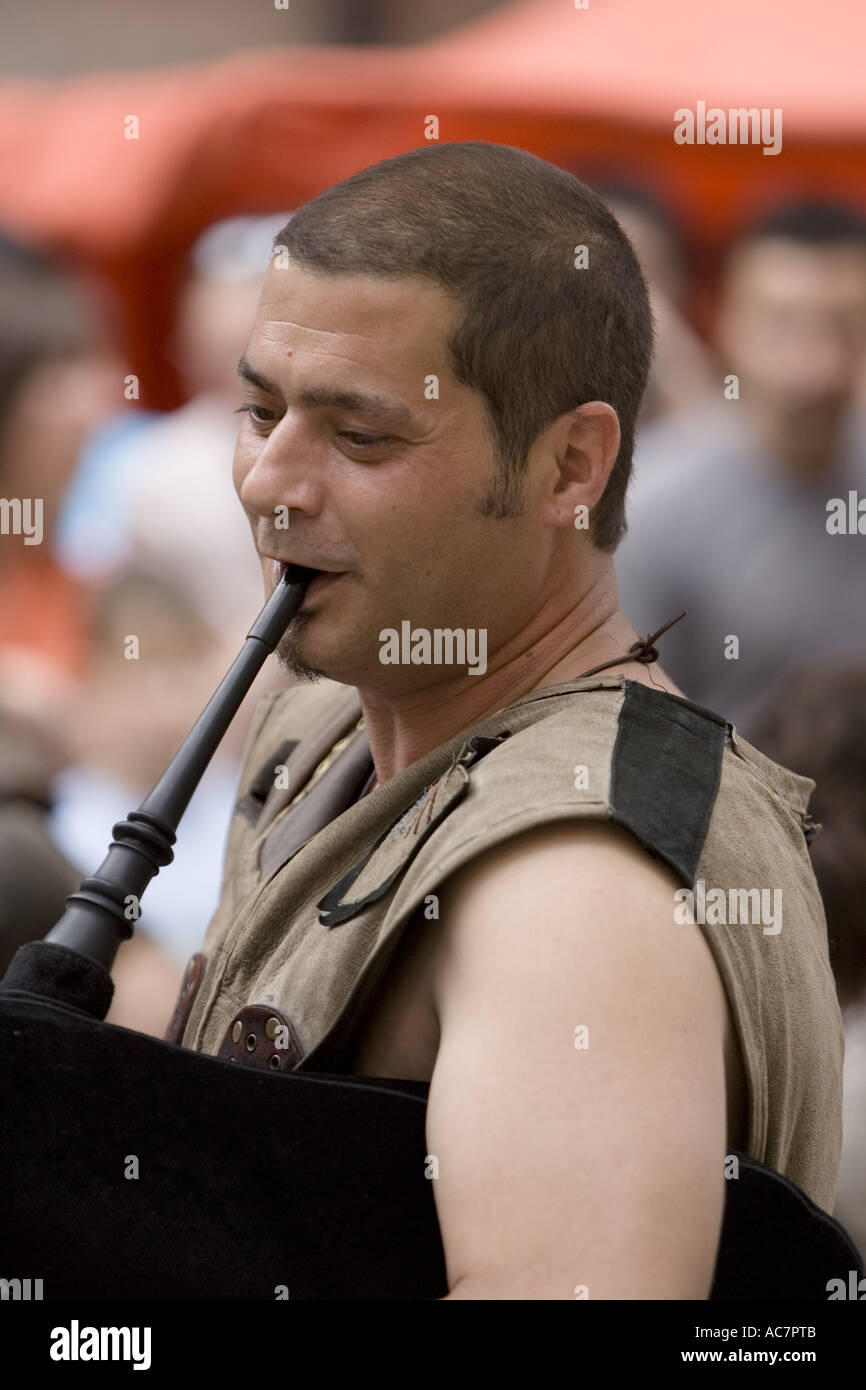 Male musician in period dress playing bagpipes at a Medieval market ...