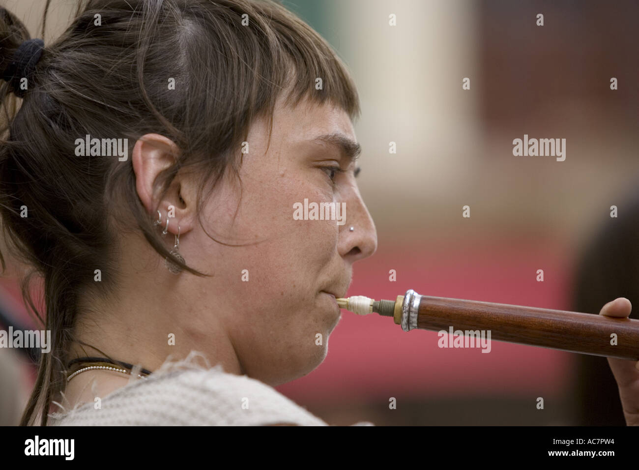 Female musician in period dress playing wind instrument at a Medieval ...