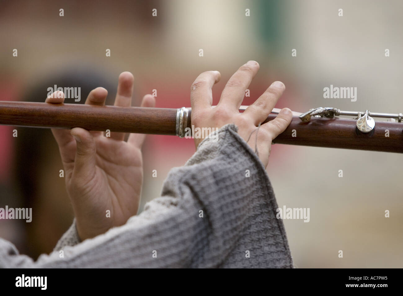 Female musician in period dress playing flute at a medieval market ...