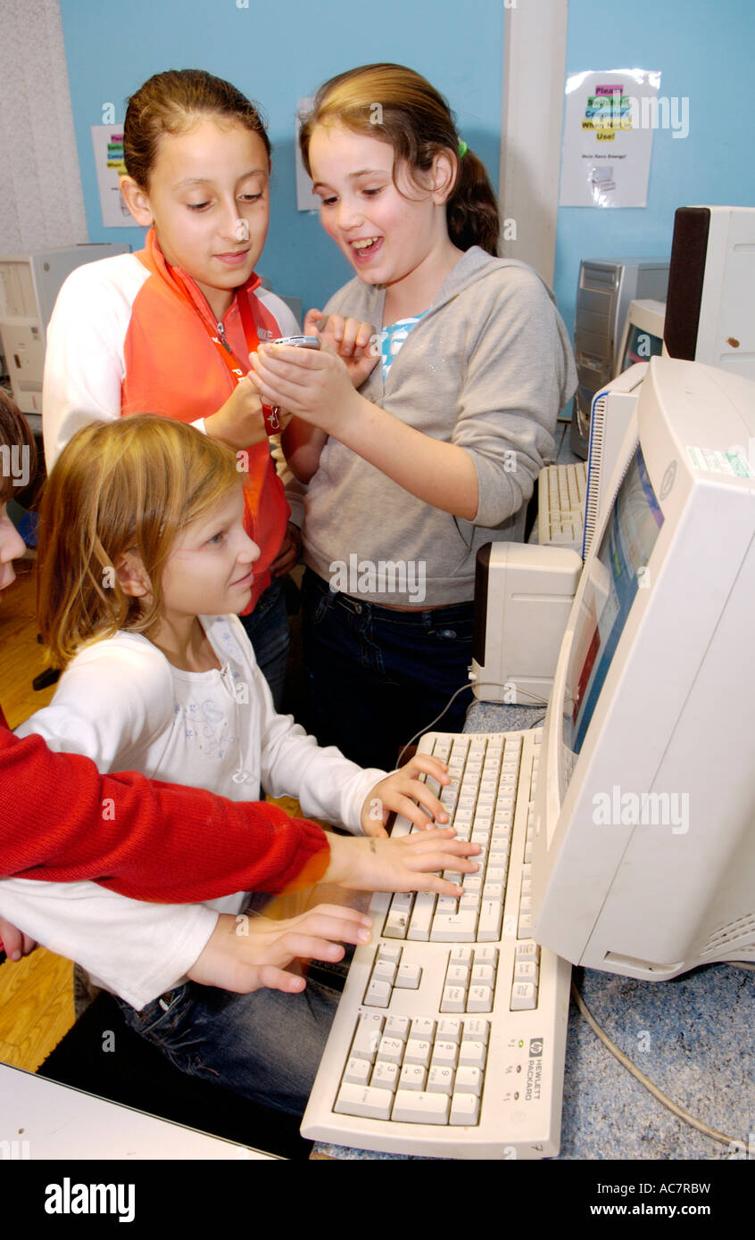 Young girls playing on computer and mobile phone in youth club UK Stock ...