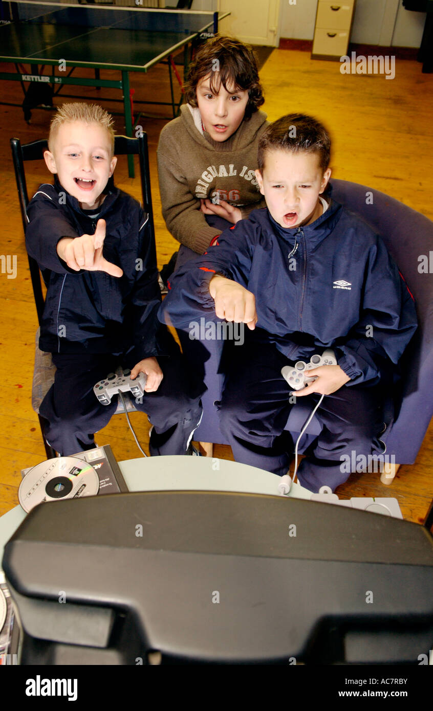 Three young boys playing computer game in youth club UK Stock Photo - Alamy