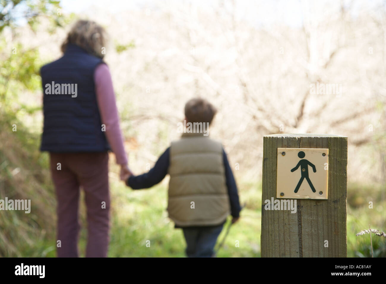 mother and child walking a track with sign Stock Photo - Alamy