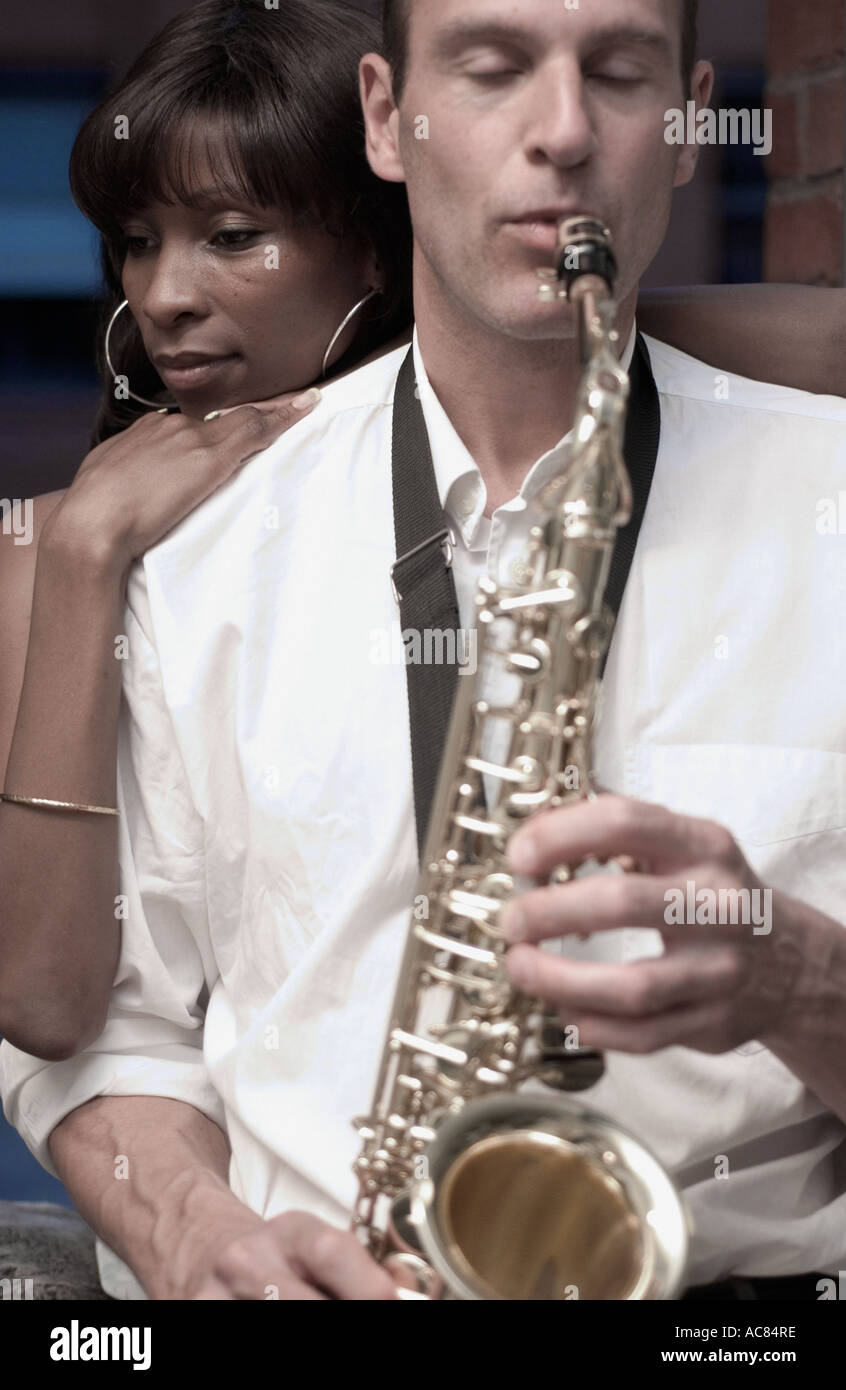 Saxophon player with a dark skinned woman both mid 30 s on his side ...