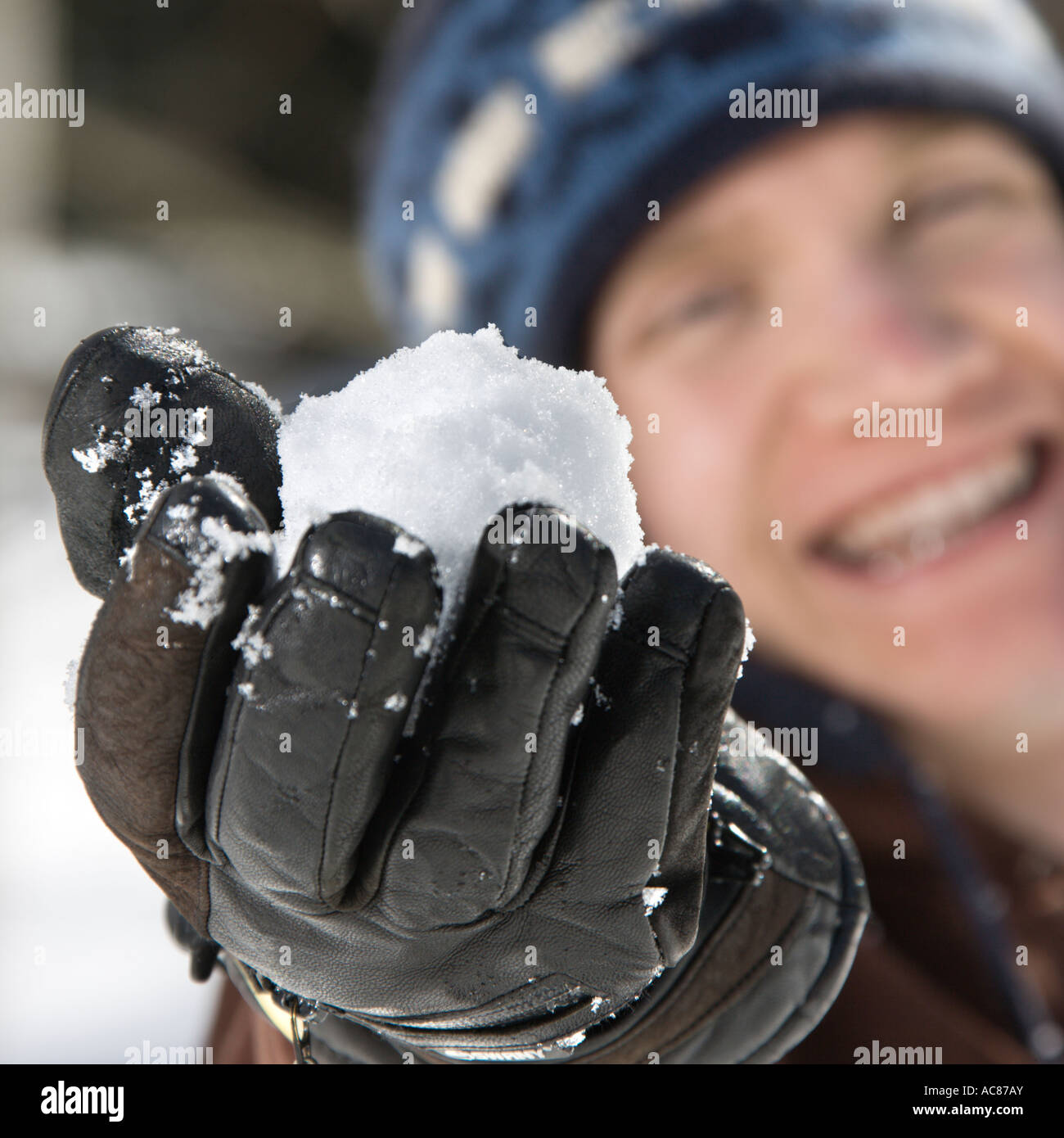 Caucasian male teenager holding snowball out towards viewer Stock Photo ...