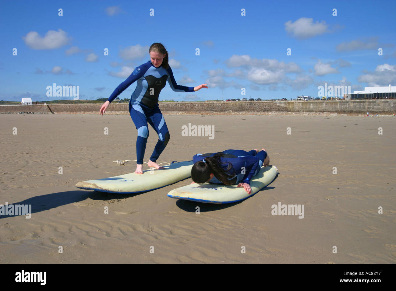 Two young teenage girls first surfing lesson on St Ouen's Beach Jersey ...