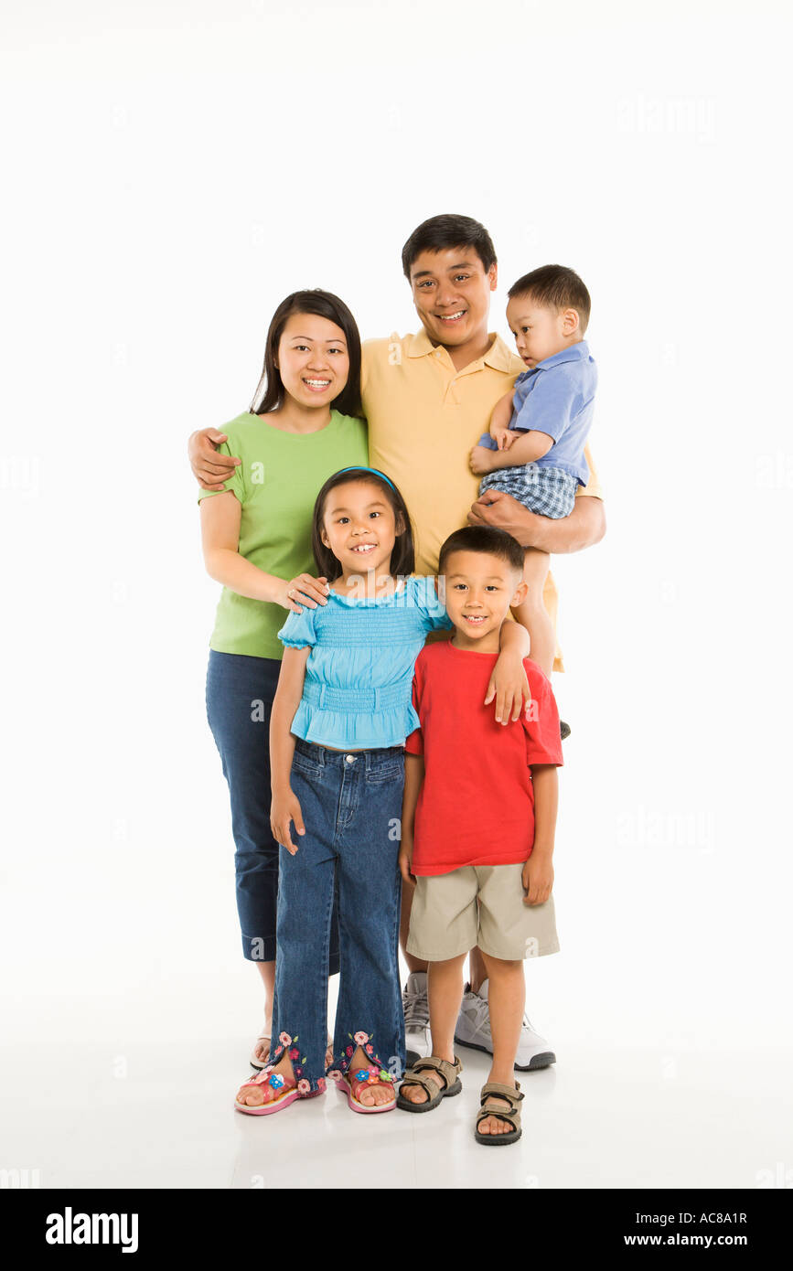 Asian parents with three children standing in front of white background ...