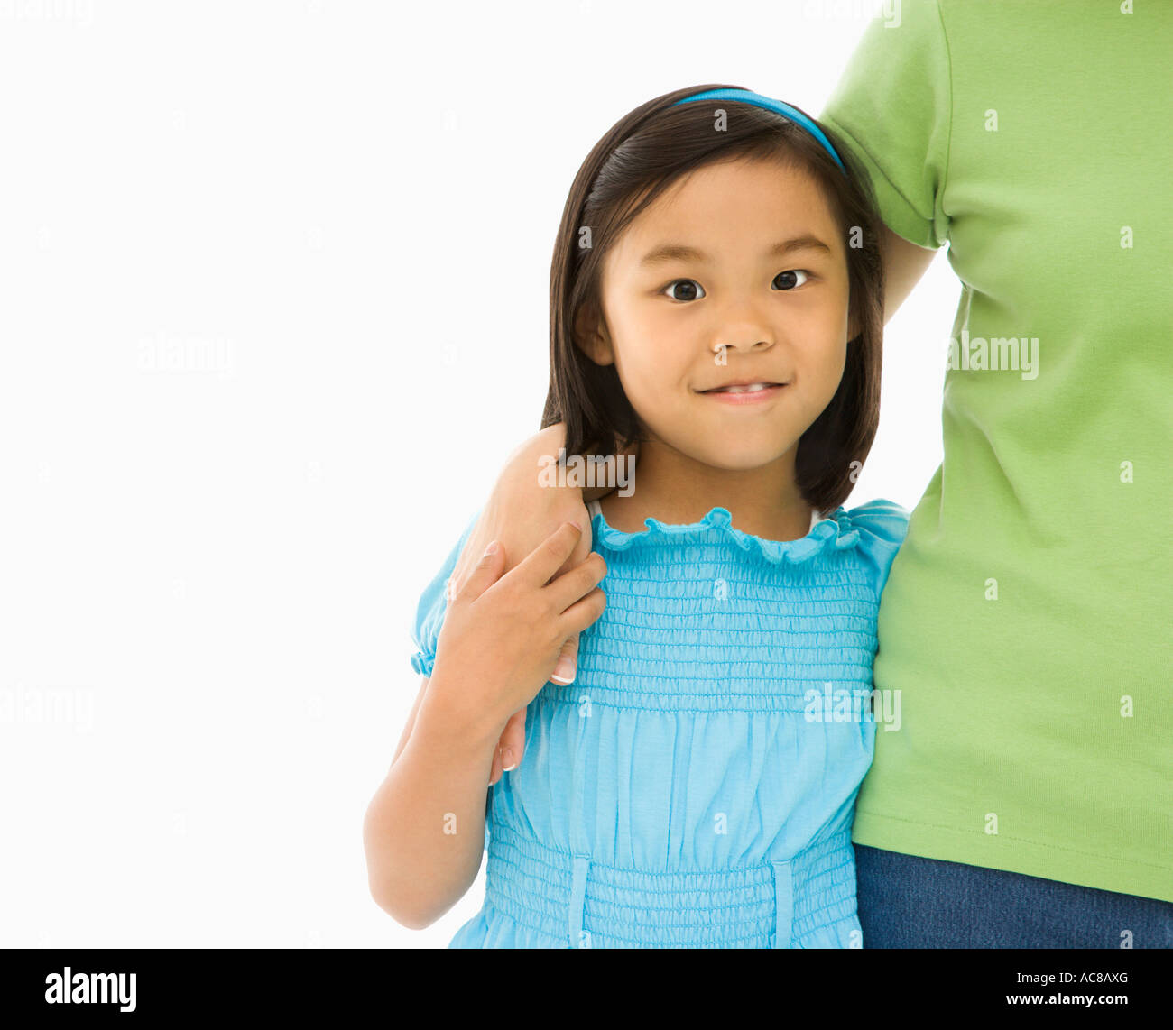 Asian Mother And Daughter Standing With Arms Around Eachother Stock