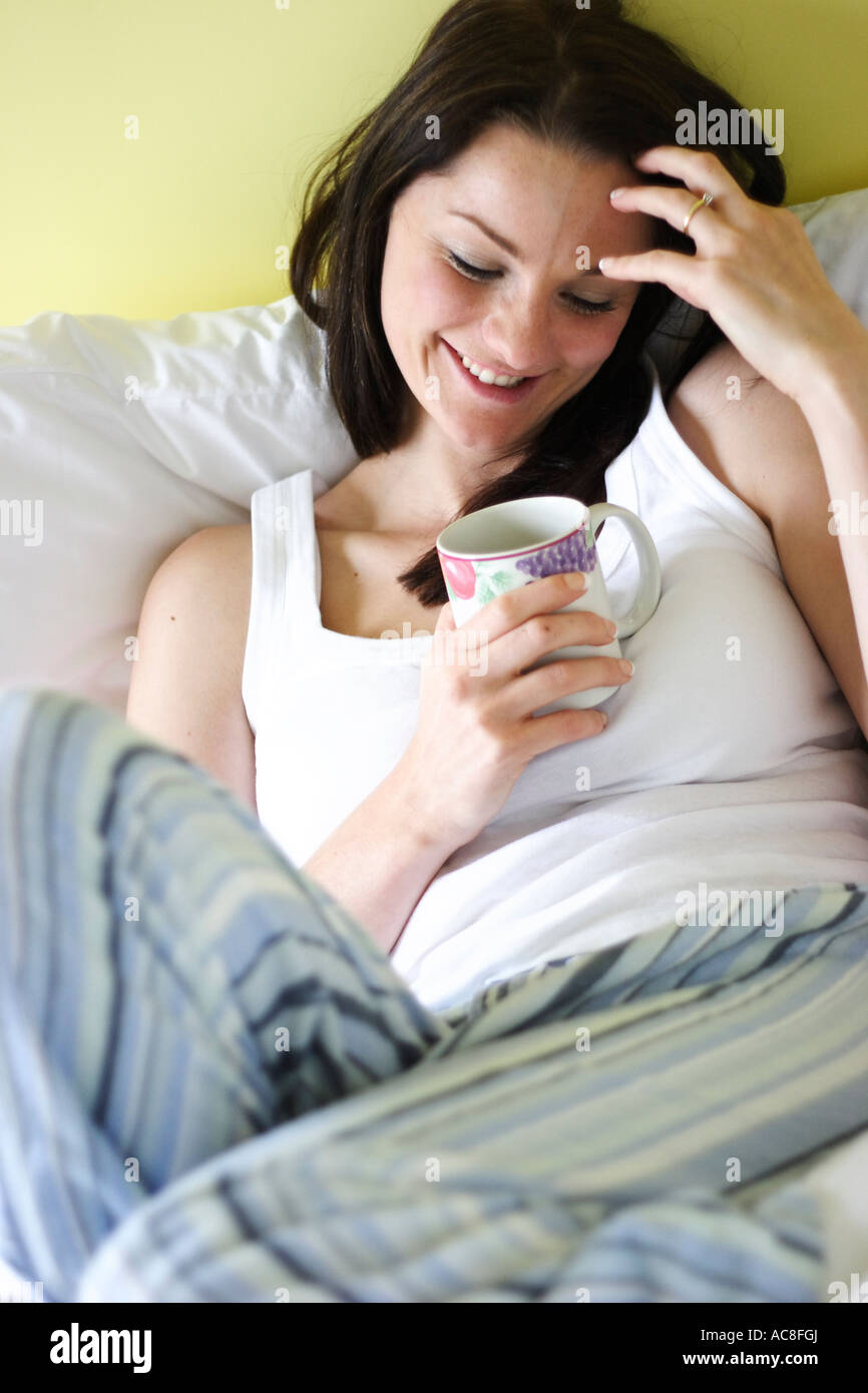 Young woman smiling in bed Stock Photo - Alamy
