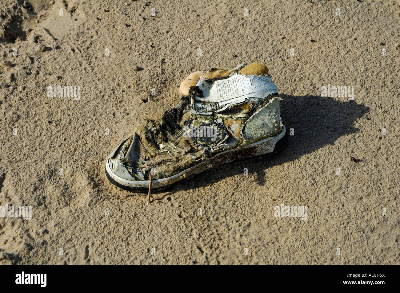 A discarded shoe on the beach at Camber Sand Rye East Sussex England ...
