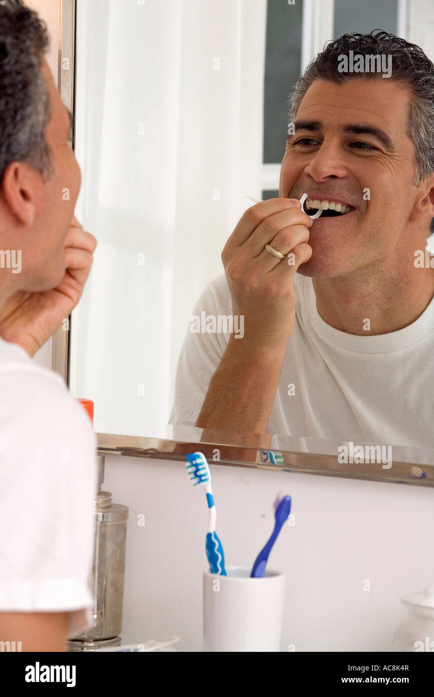 Mature man flossing his teeth Stock Photo - Alamy