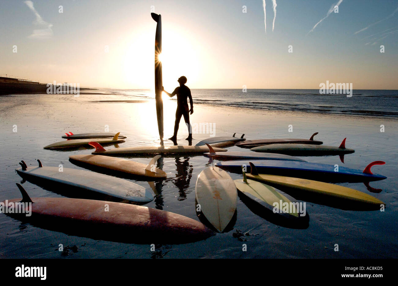 Surfboarder on Brighton beach with collection of vintage old boards ...
