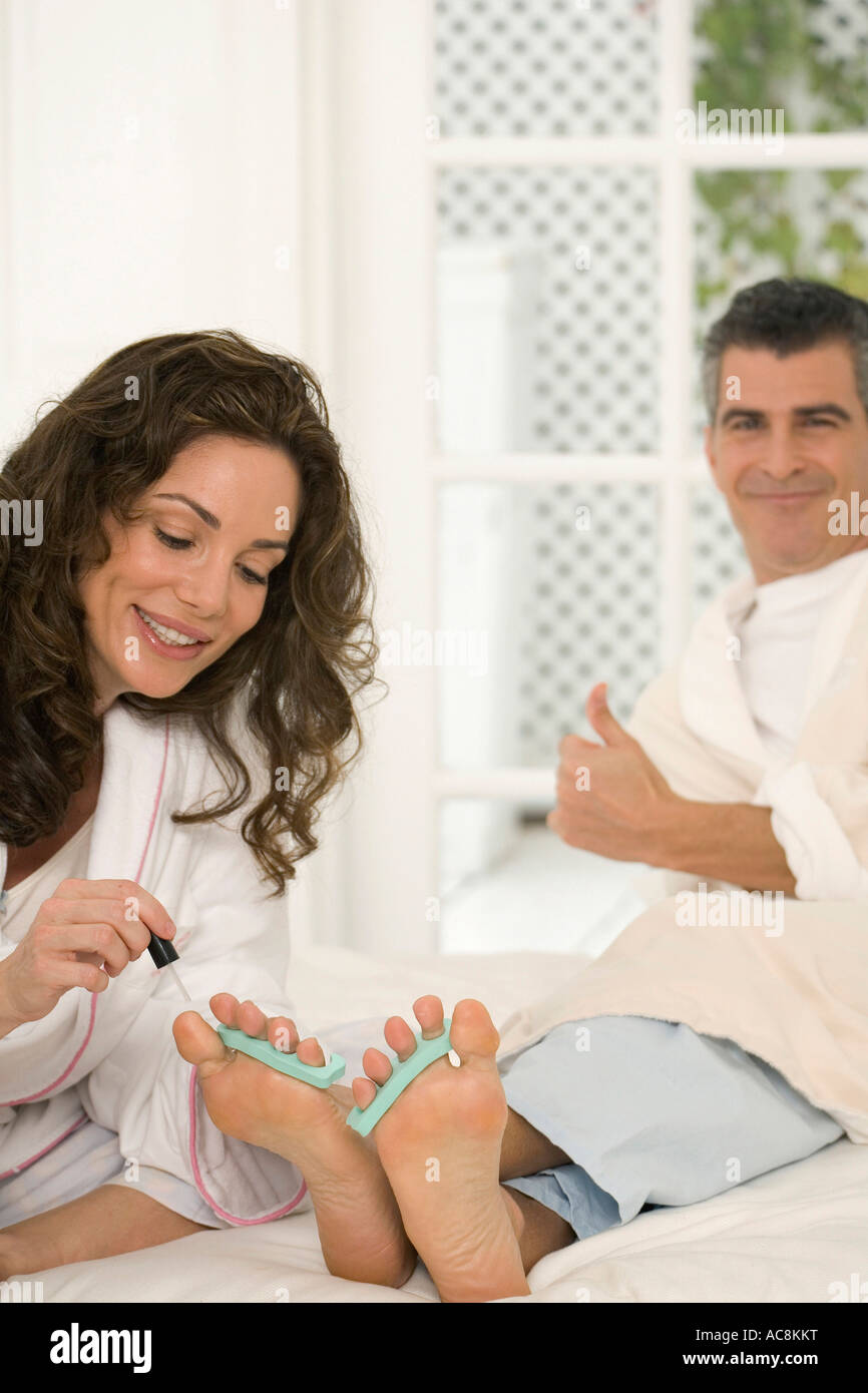 Mid adult woman painting the toenails of a mature man Stock Photo - Alamy