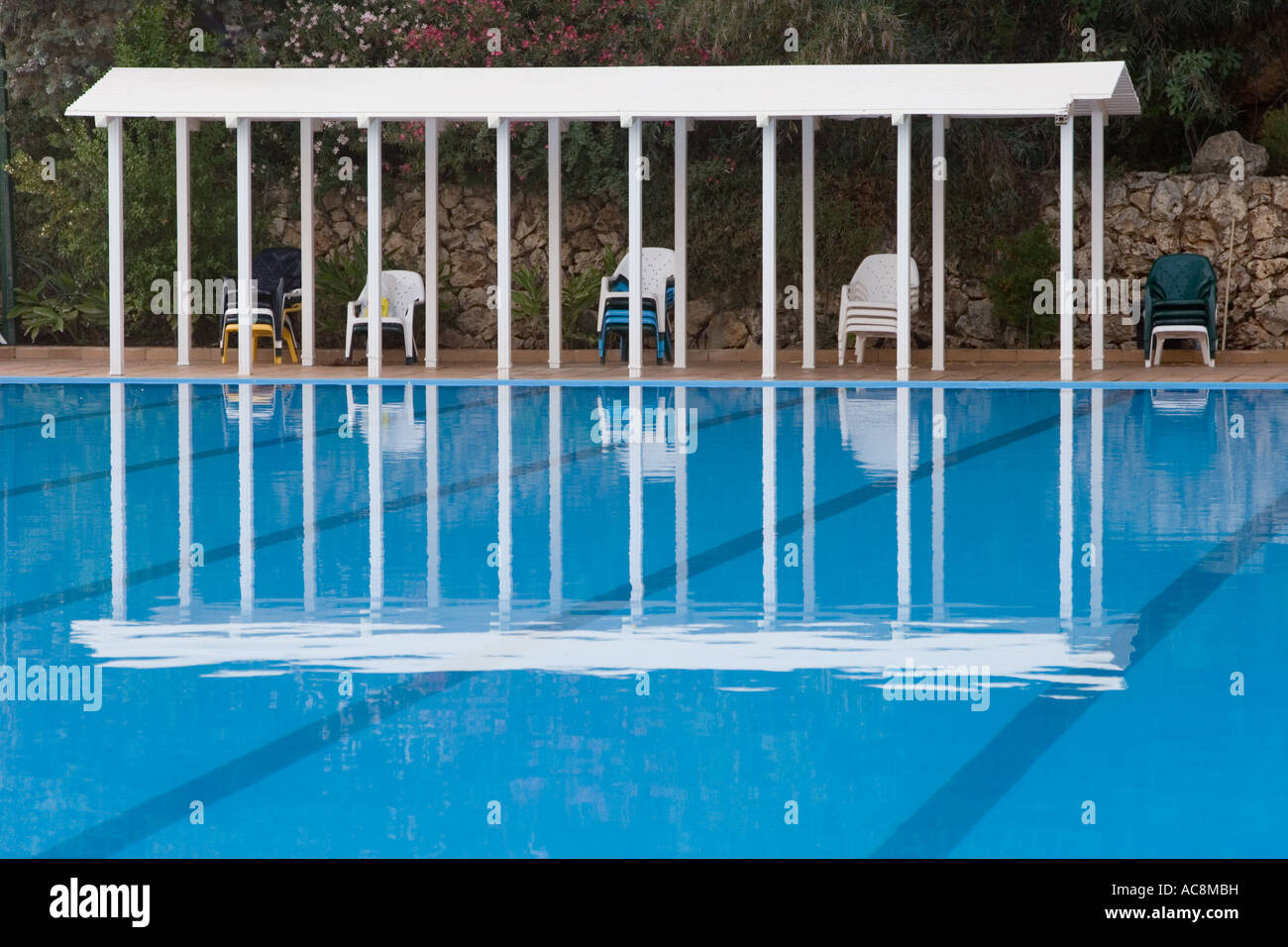 Stock photo of a white poolside pavilion reflecting in blue pool water ...