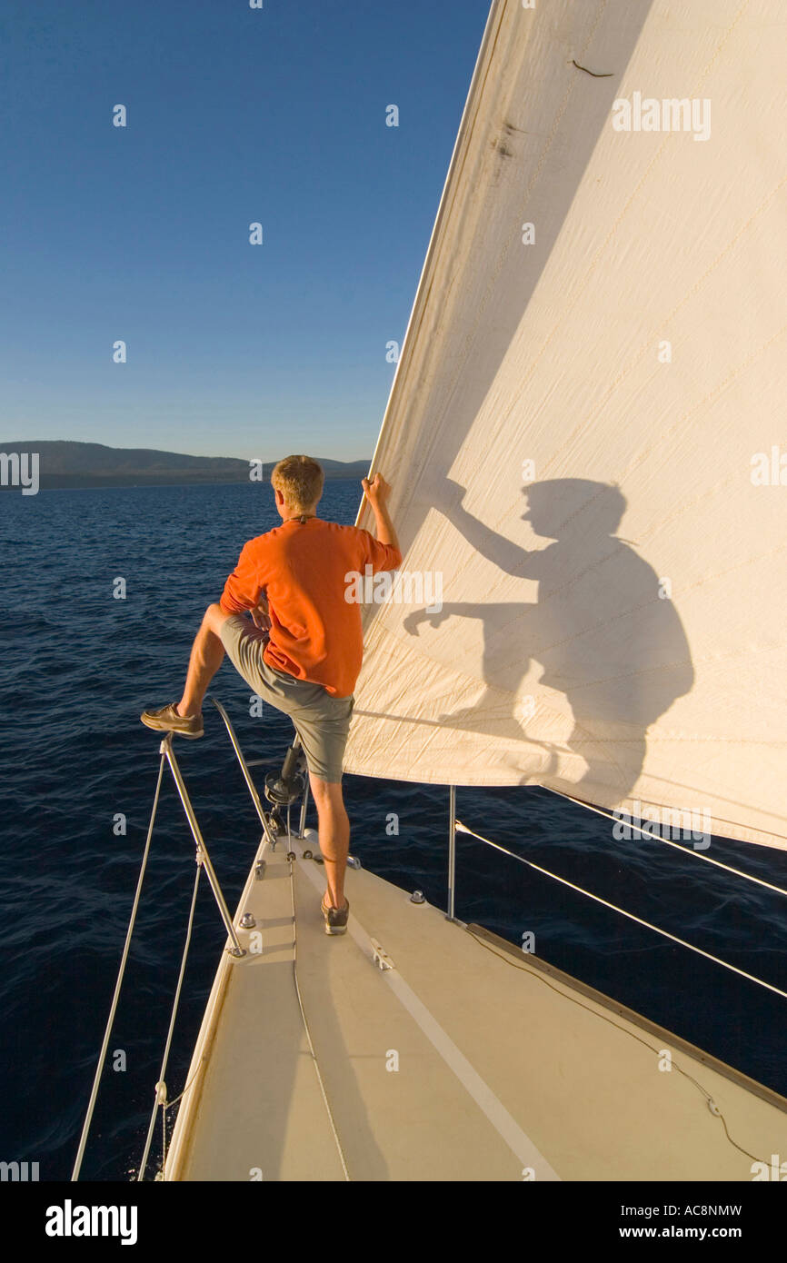 Rear view of a man standing on a sailboat Stock Photo - Alamy
