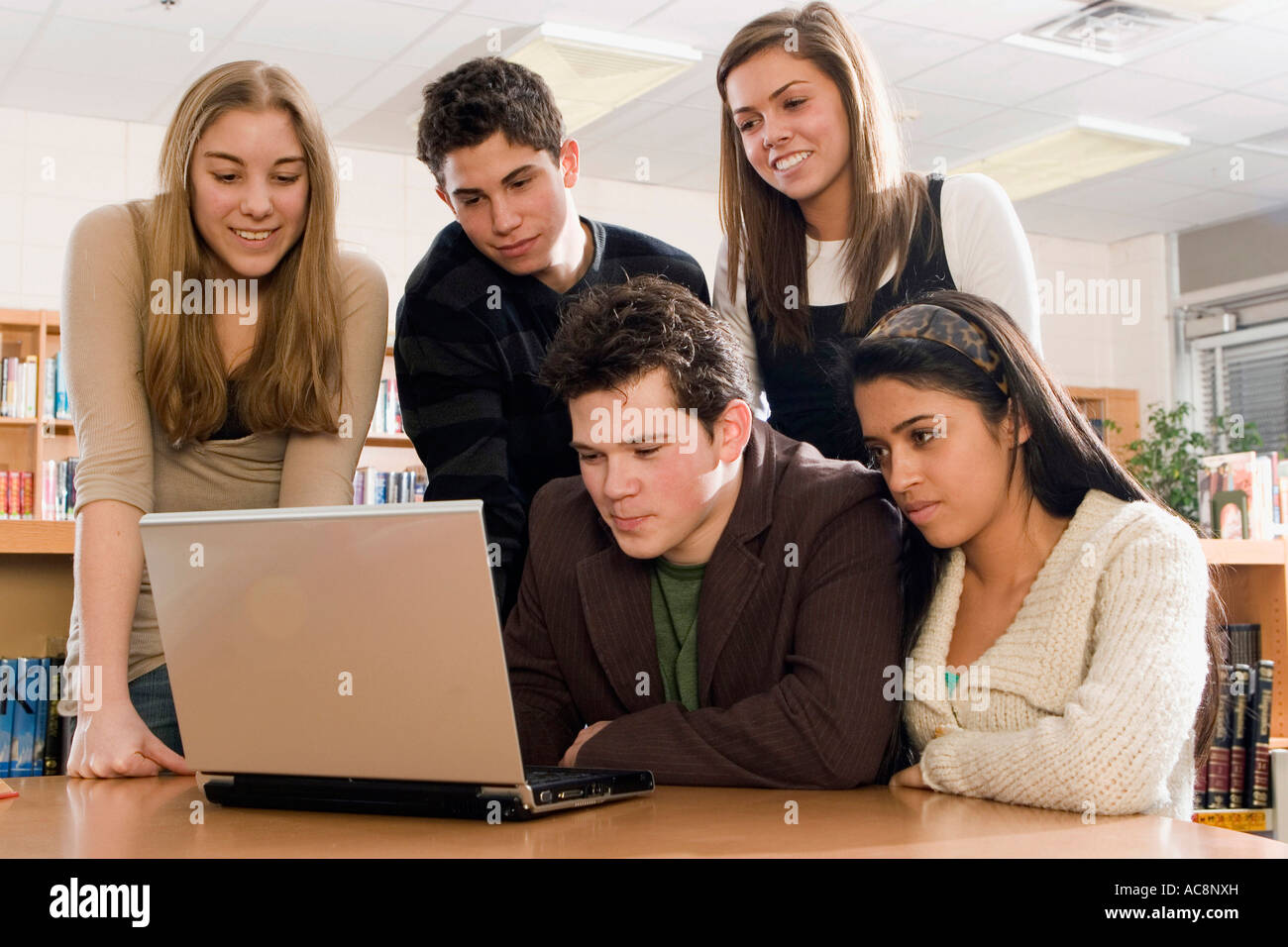 Five students looking at a laptop Stock Photo - Alamy