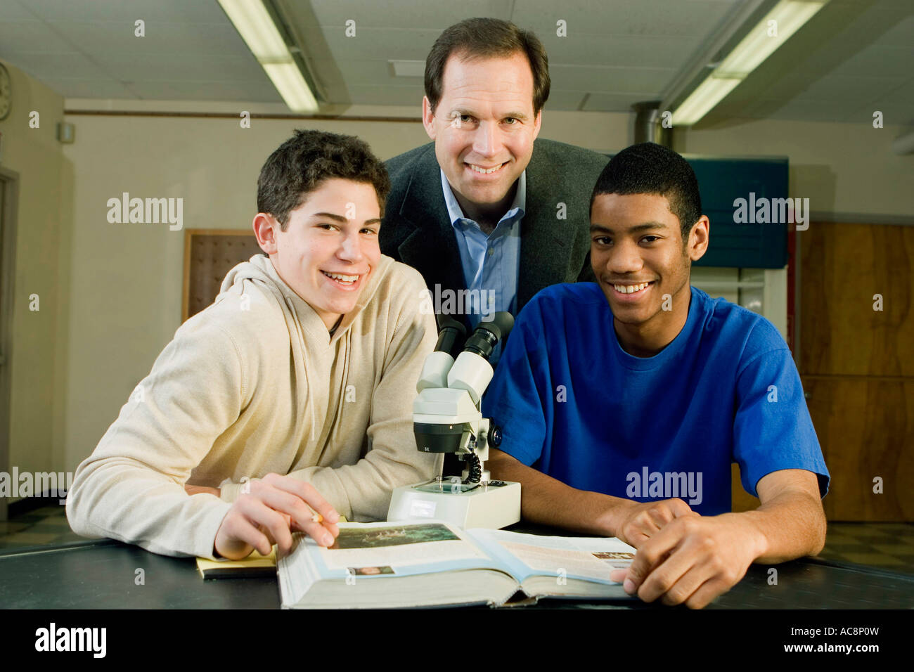 Two students with their teacher in a science lab Stock Photo - Alamy