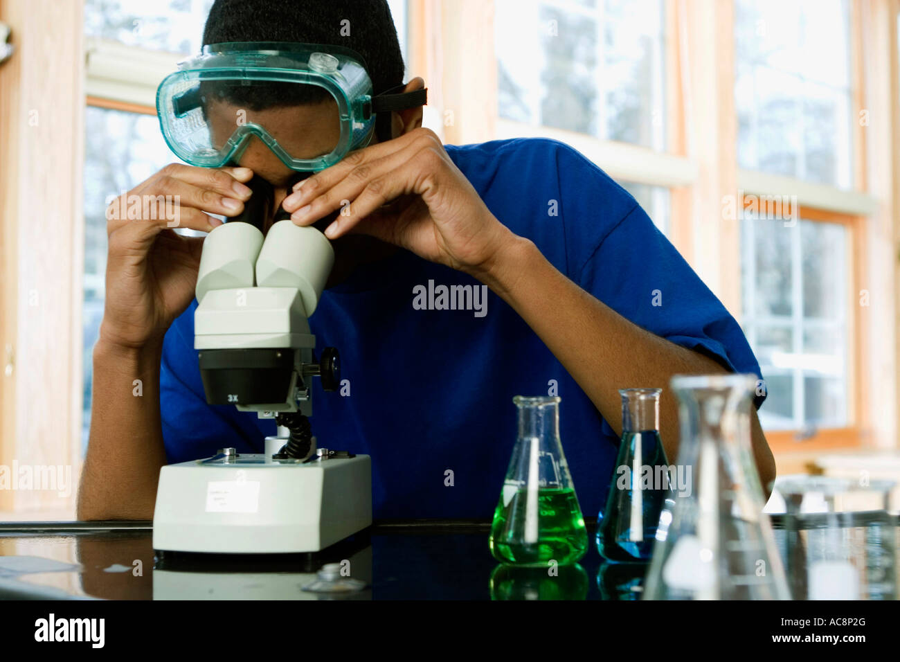 Student looking through a microscope in a science lab Stock Photo - Alamy