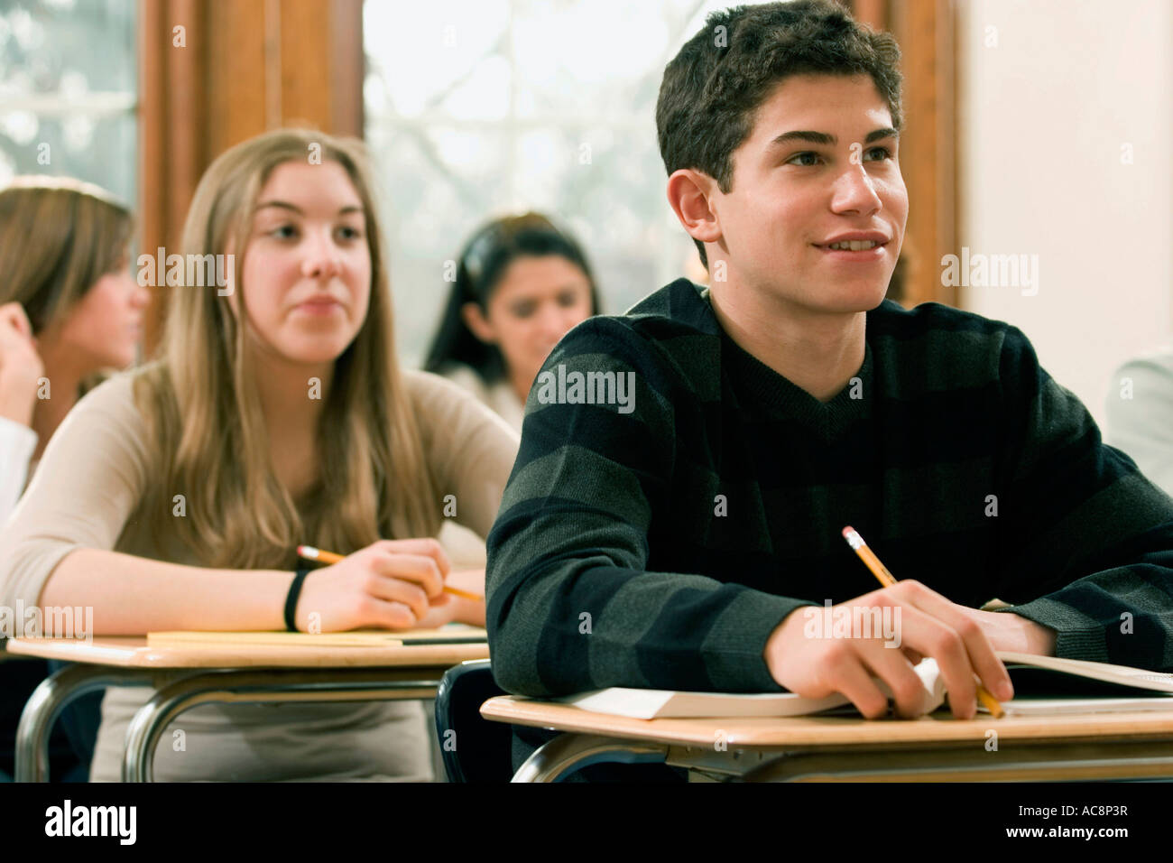 Students sitting at their desks in a classroom Stock Photo - Alamy