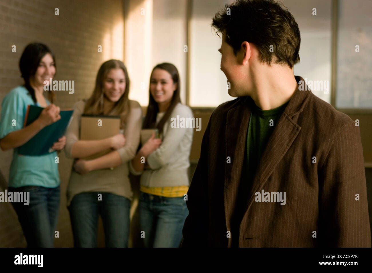 Four students standing in a corridor Stock Photo - Alamy