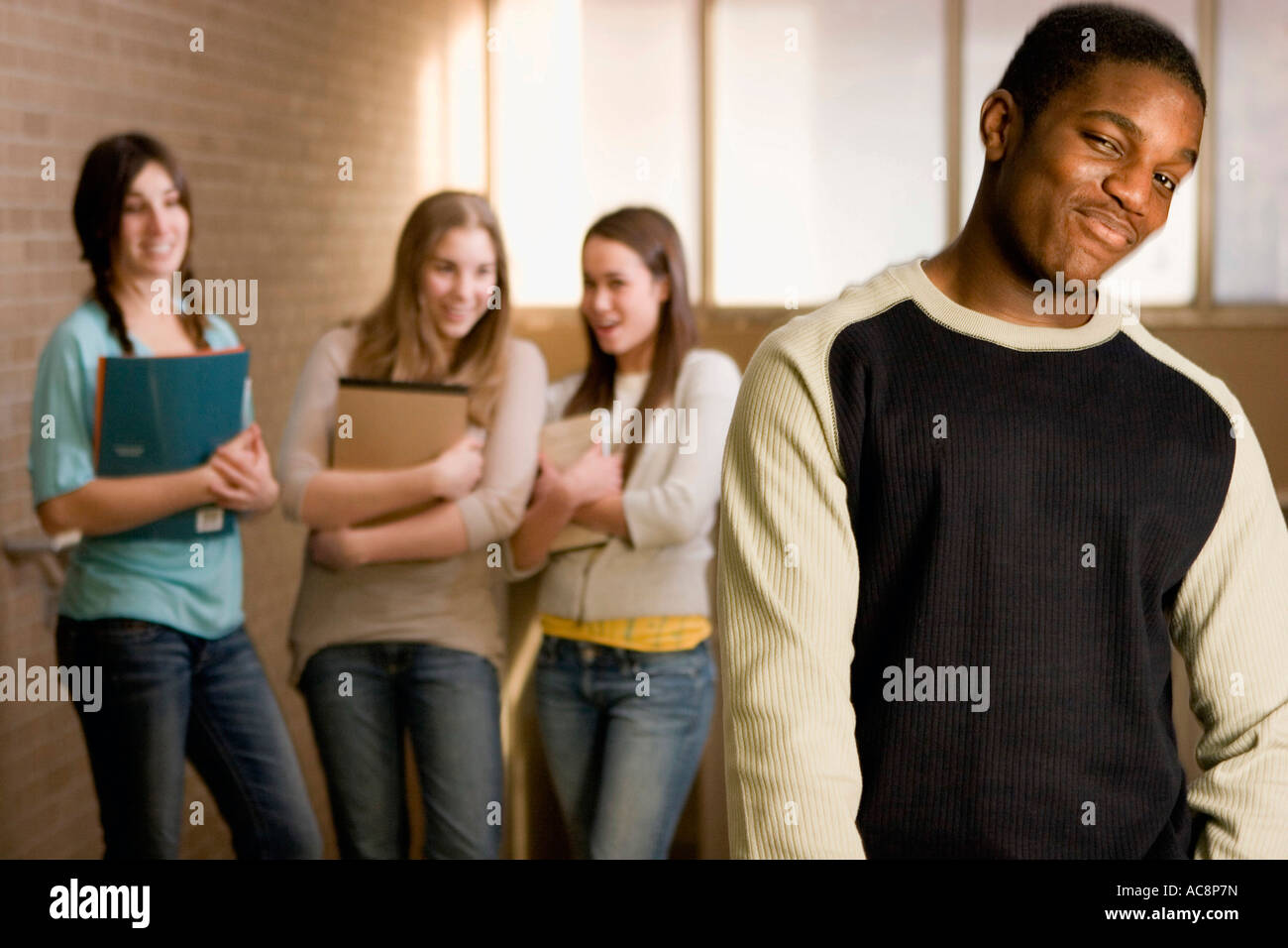 Four students standing in a corridor Stock Photo - Alamy