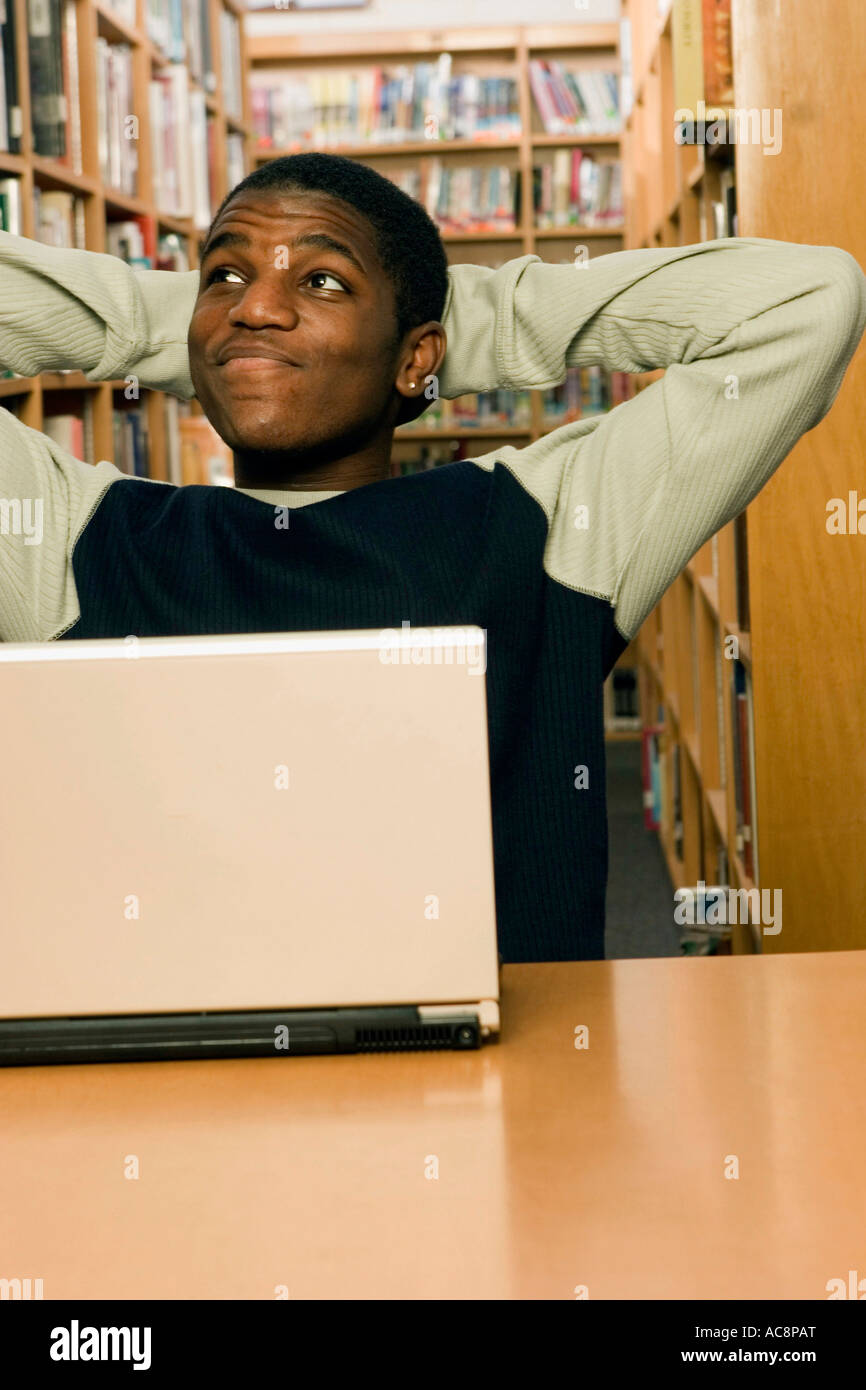 Student sitting in front of a laptop in a library Stock Photo - Alamy