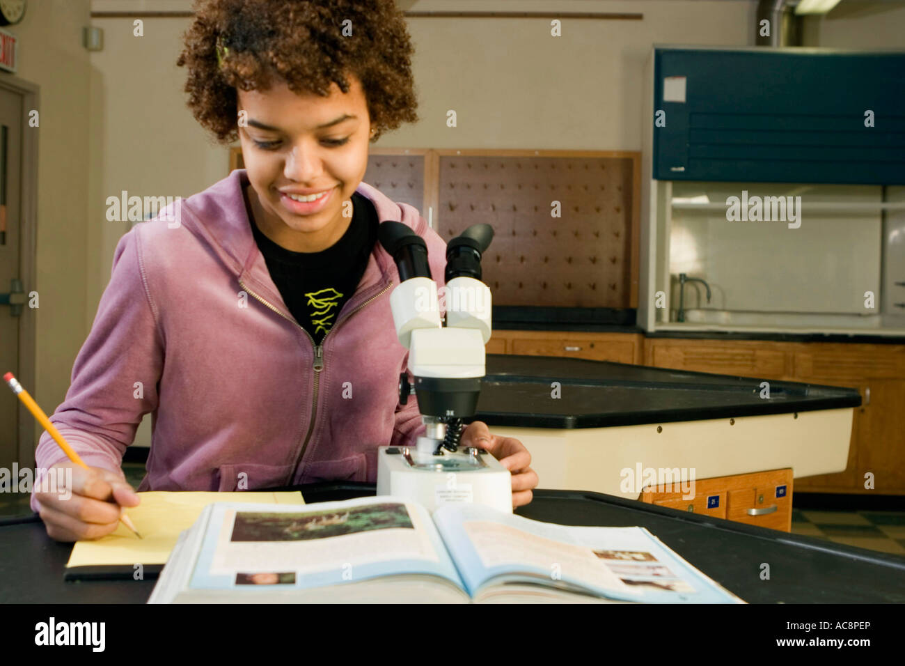 Student writing in a science lab Stock Photo - Alamy