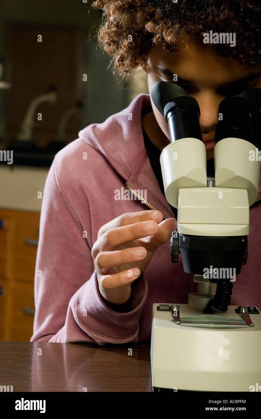 Close-up of a student looking through a microscope Stock Photo - Alamy